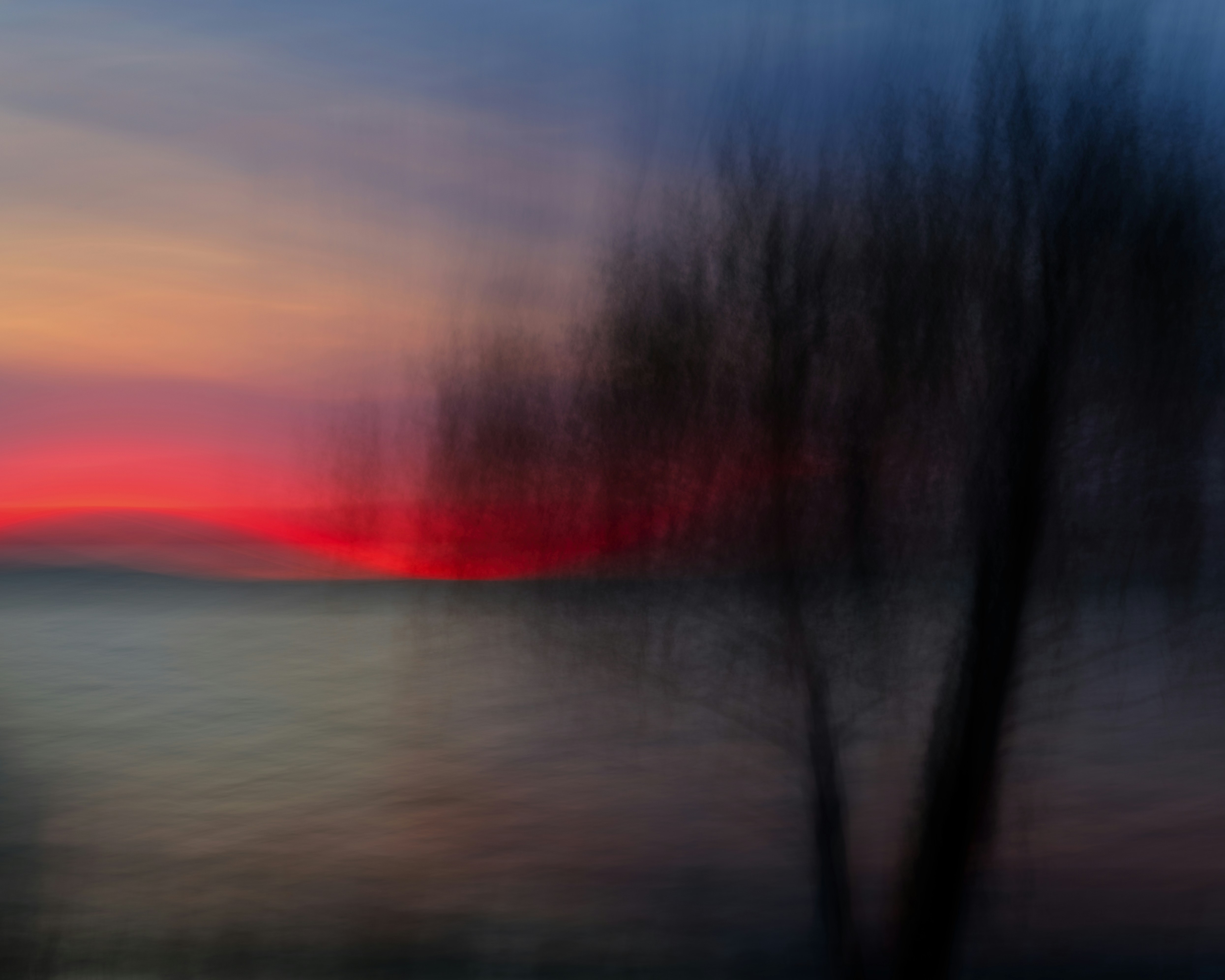 A blurry photo of a sunset over a body of water photo – Free Nature ...