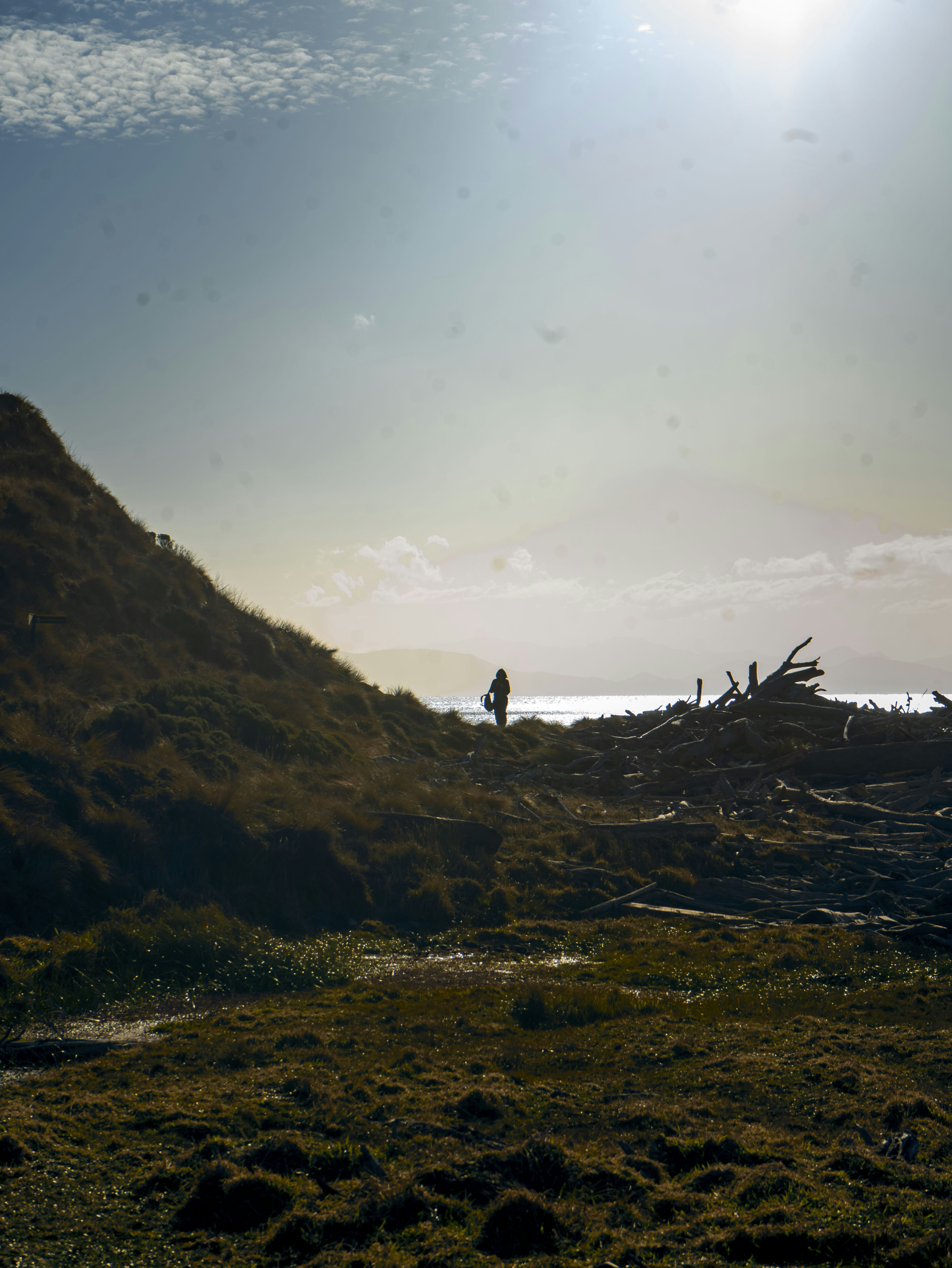 A person standing on top of a grass covered hill