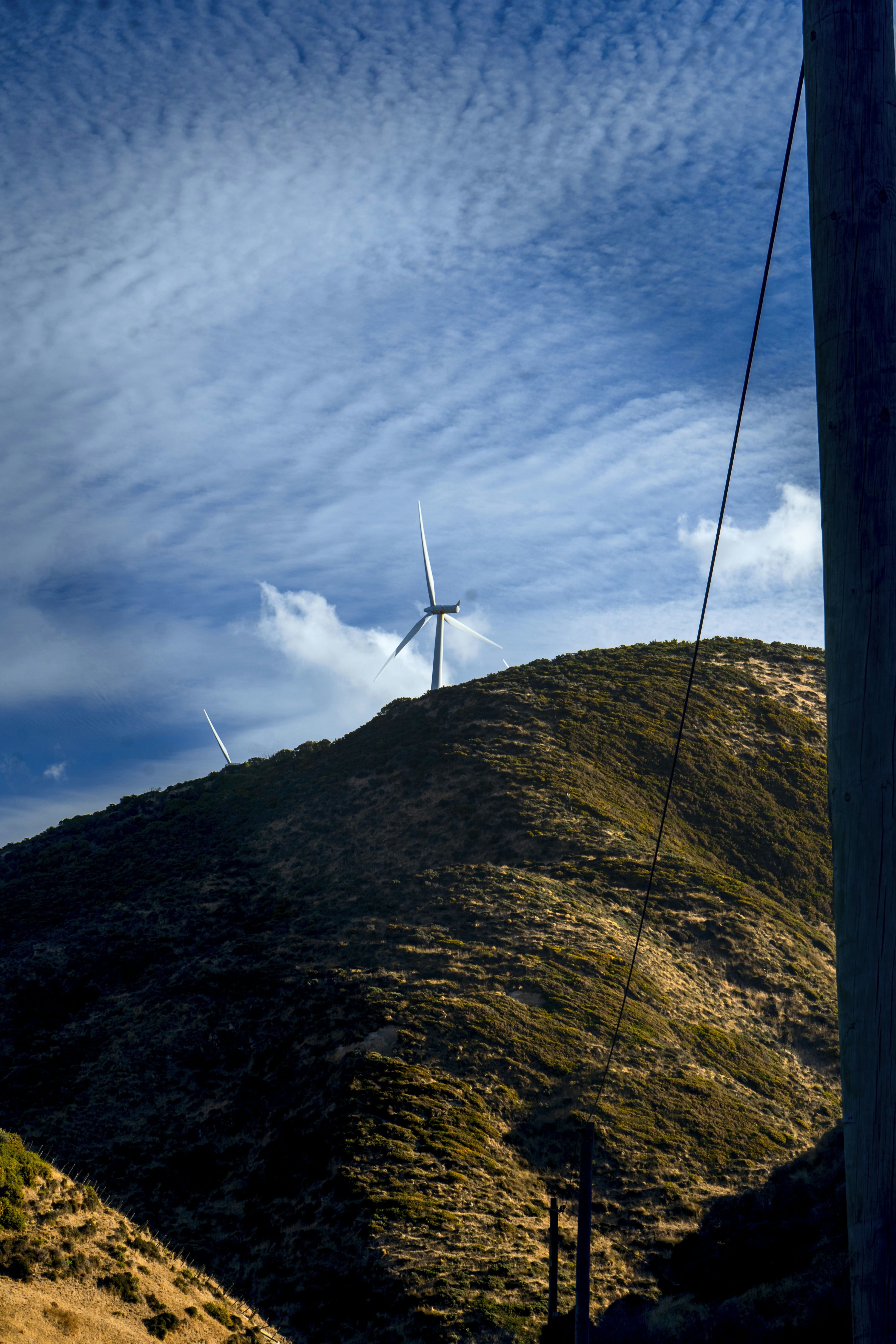 Ridge-Top Turbines Against a Cloud-Washed Blue Sky