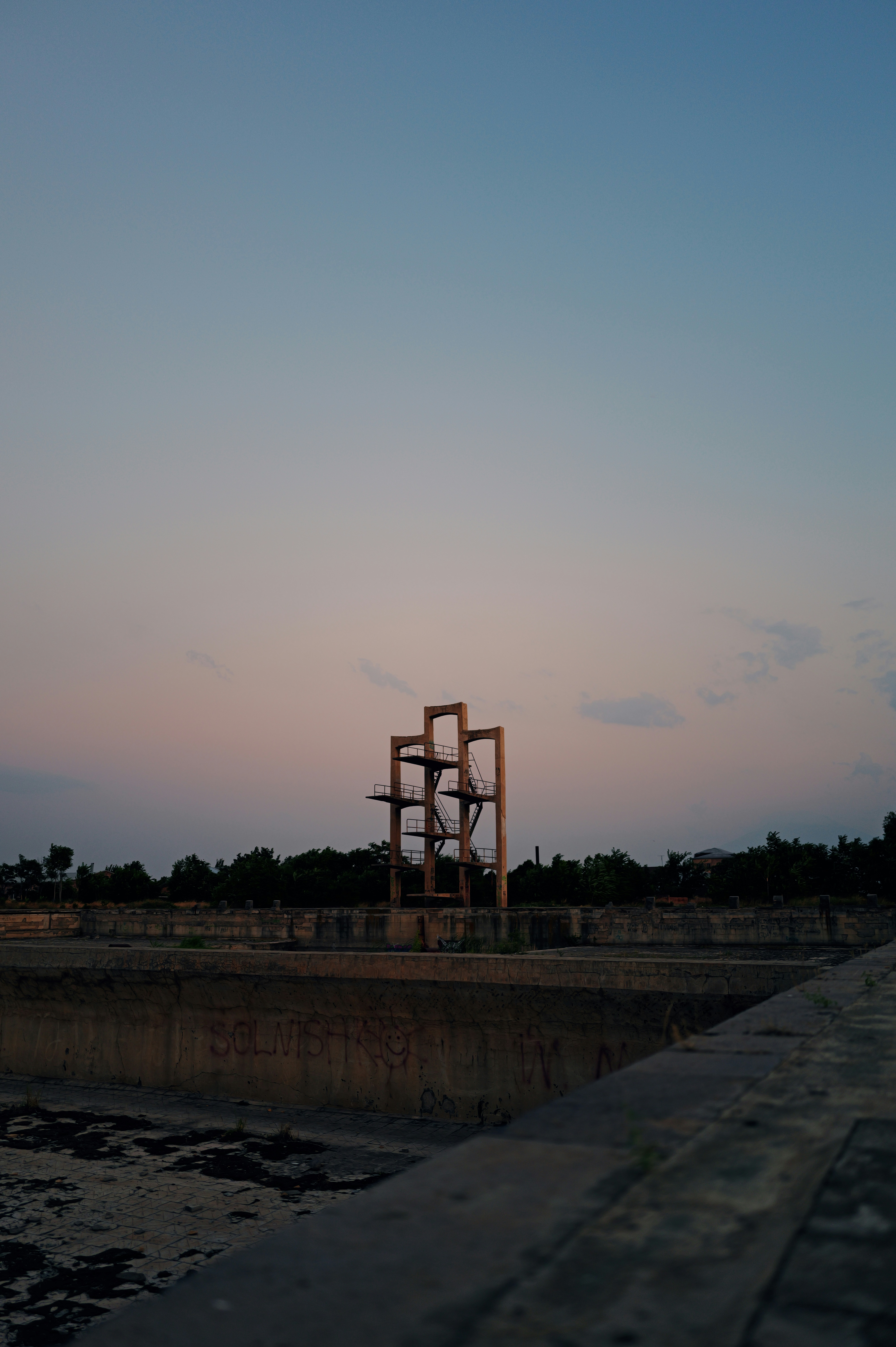 Rusted Tower at Dusk: Quiet Quay Under a Gradient Sky