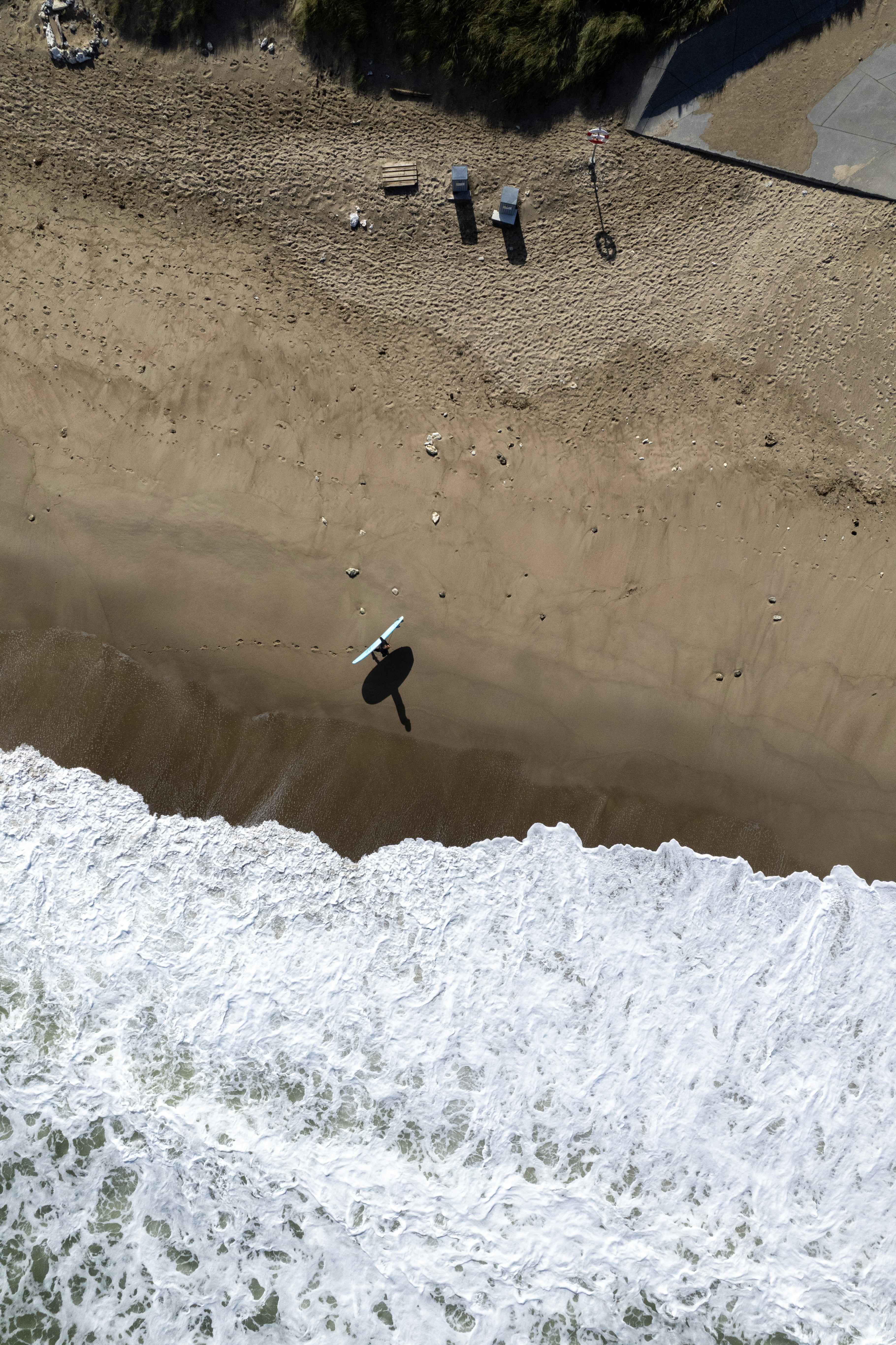 Aerial View: Surfboard, Shadow, and Shoreline at Low Tide