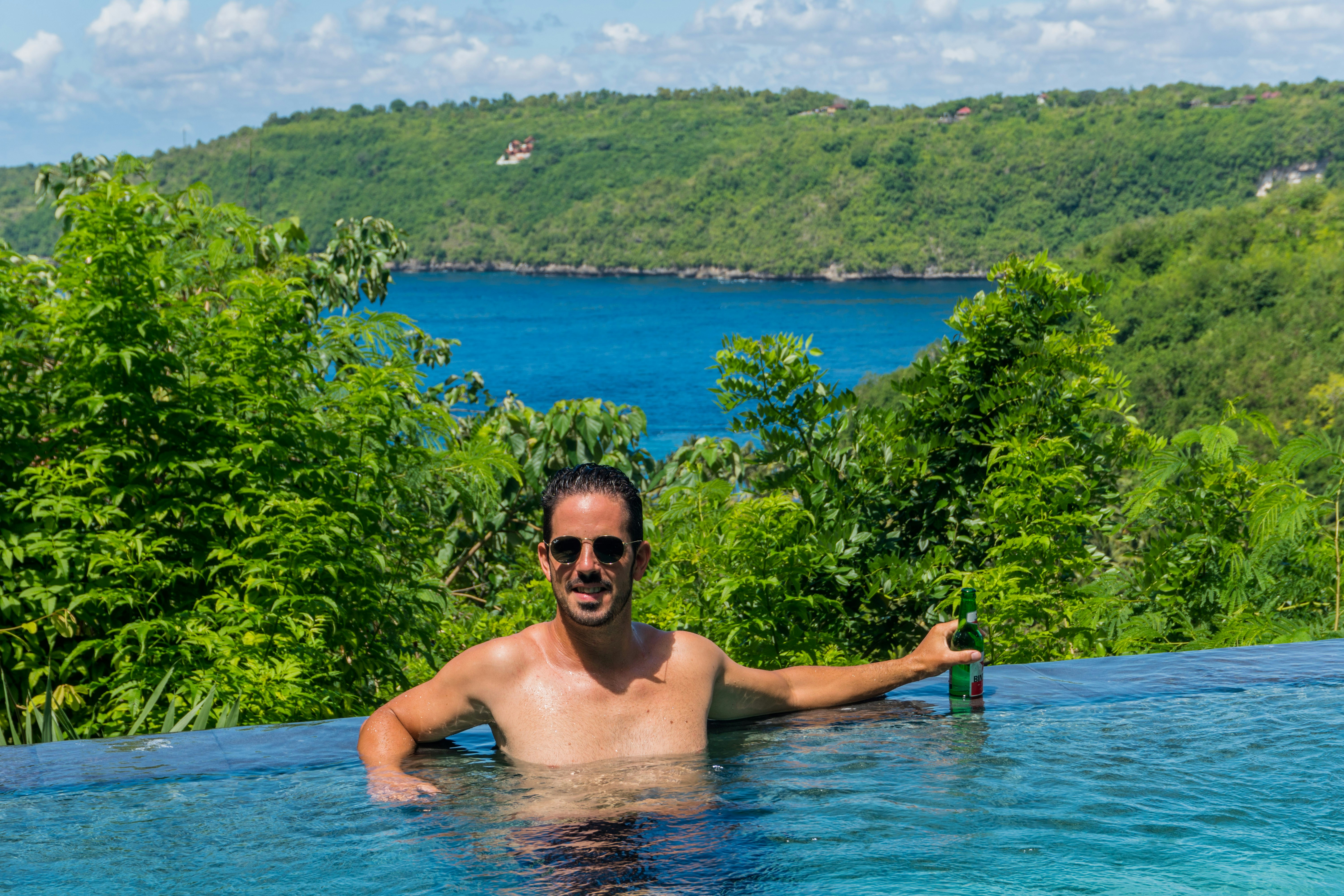 A man in a swimming pool with a bottle of wine photo – Free Infinity ...