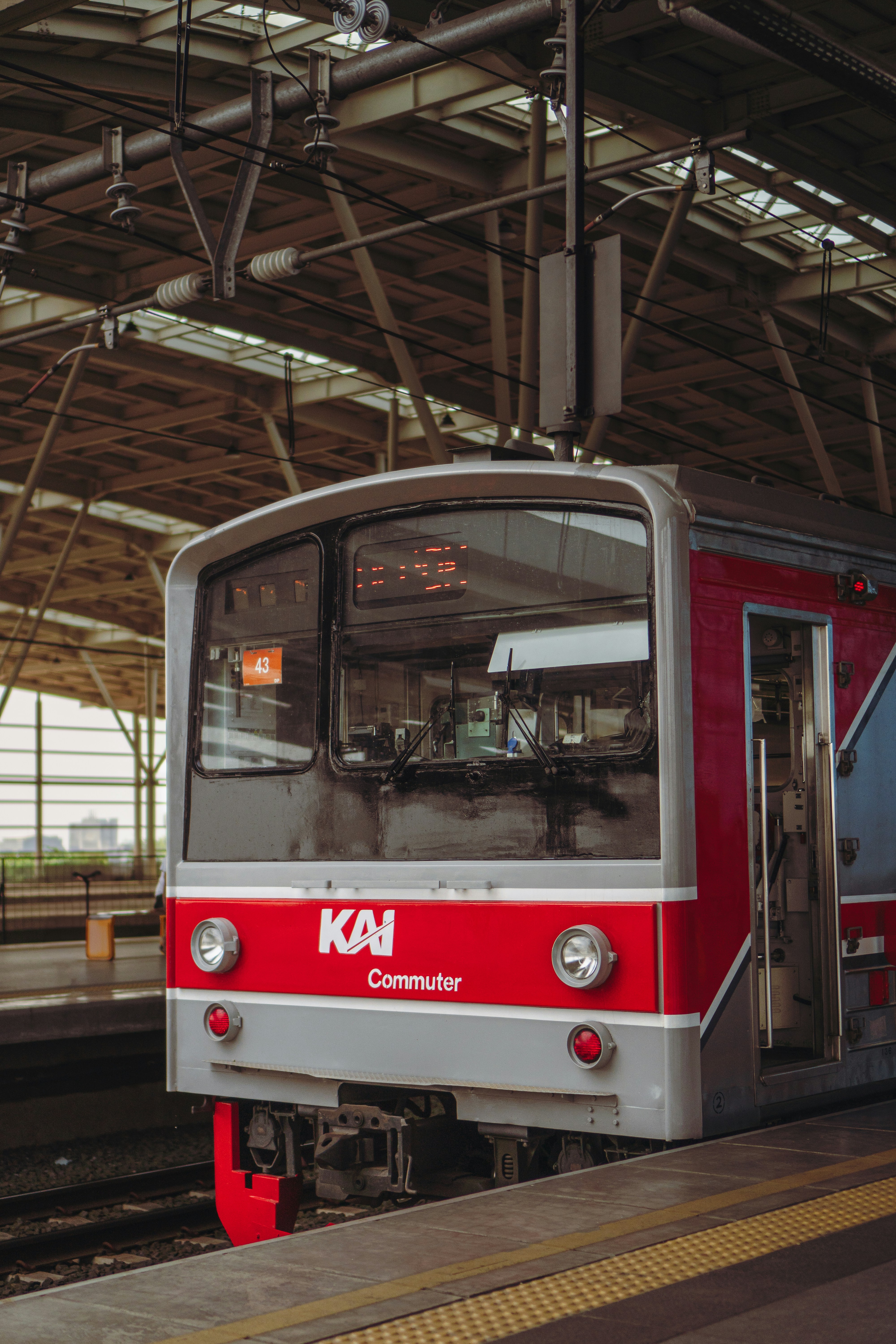 Front-View of a KAI Commuter Train Beneath a Tangle of Overhead Wires