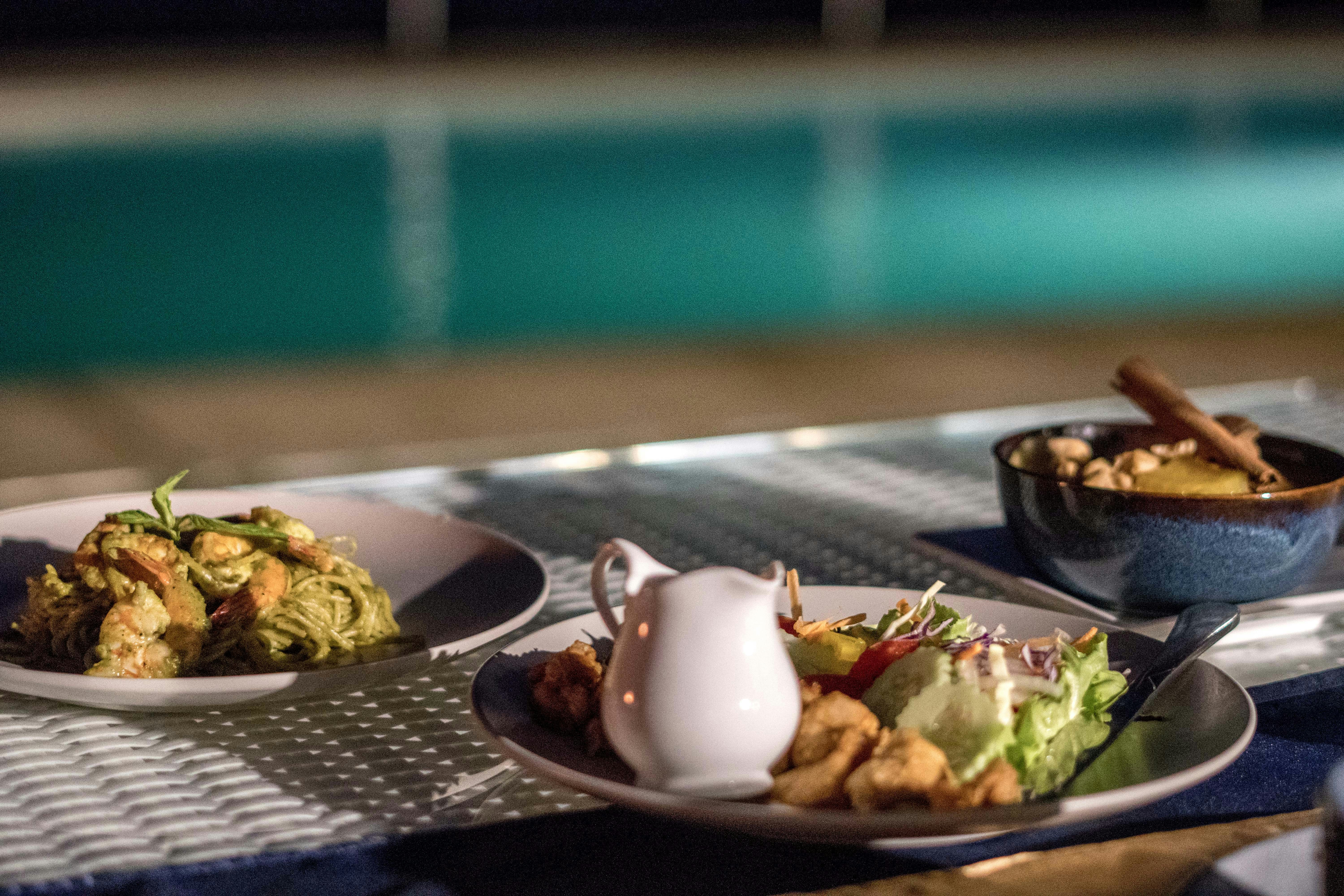Poolside Platter Glow: A Trio of Dishes Under Warm Night Bokeh