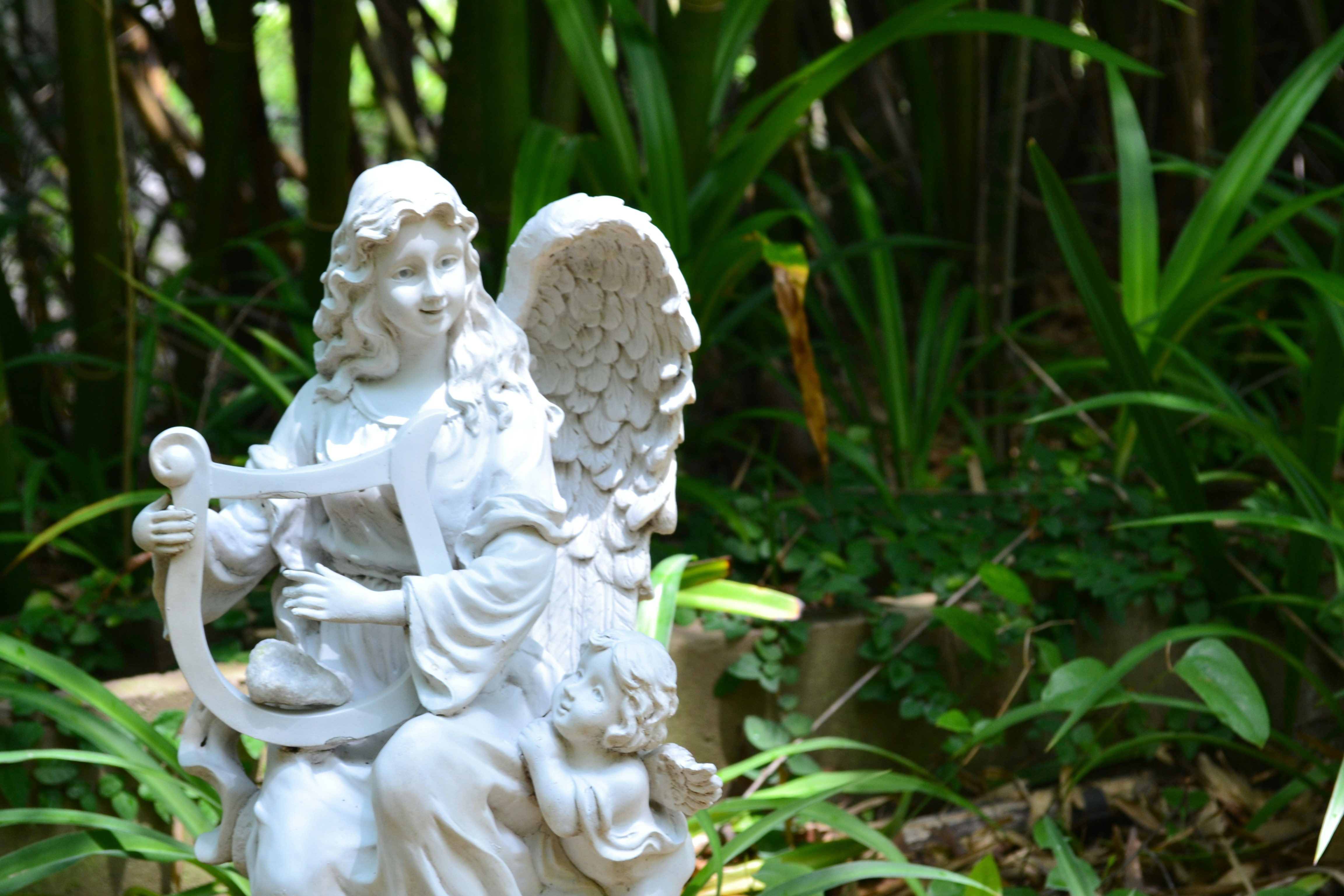 A statue of an angel with a bow and arrow photo – Free Statue Image on ...