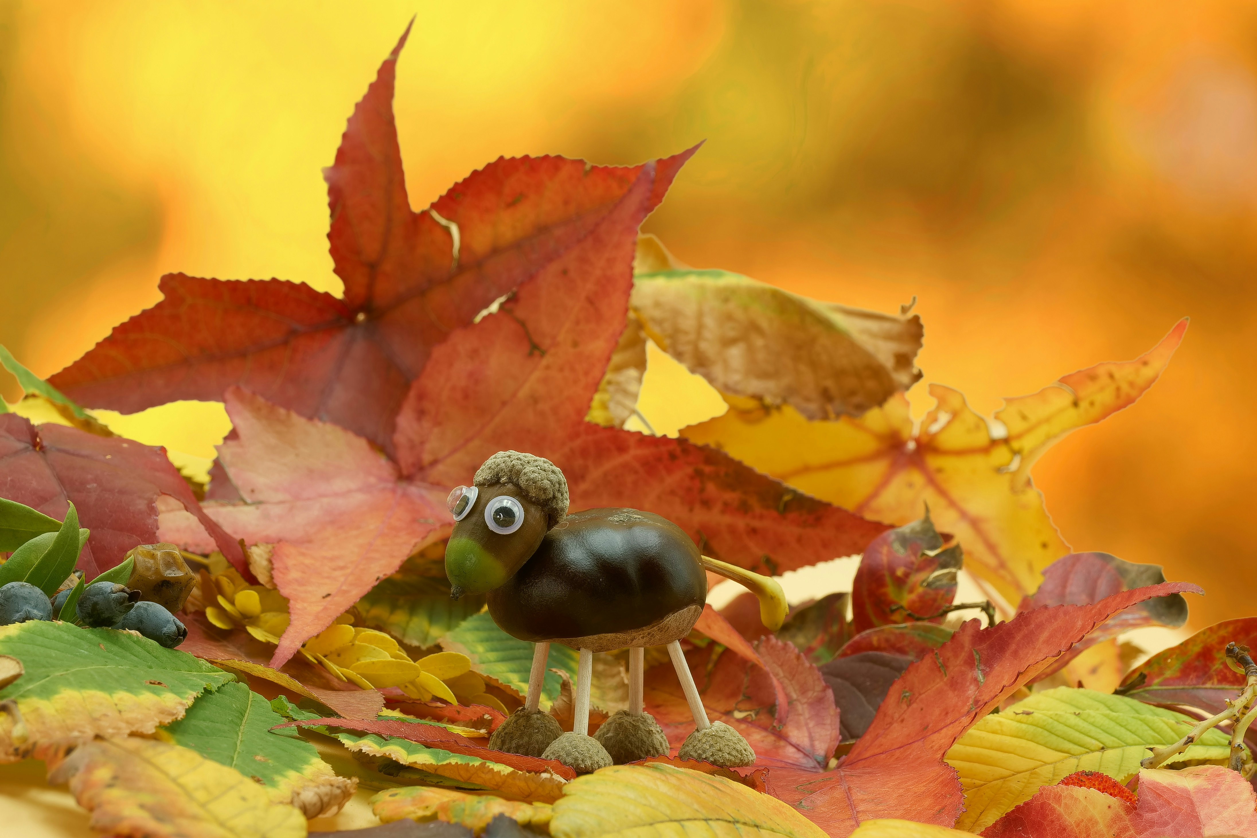 Autumn's Woolly Sentinel: A Tiny Sheep Among Maple Leaves