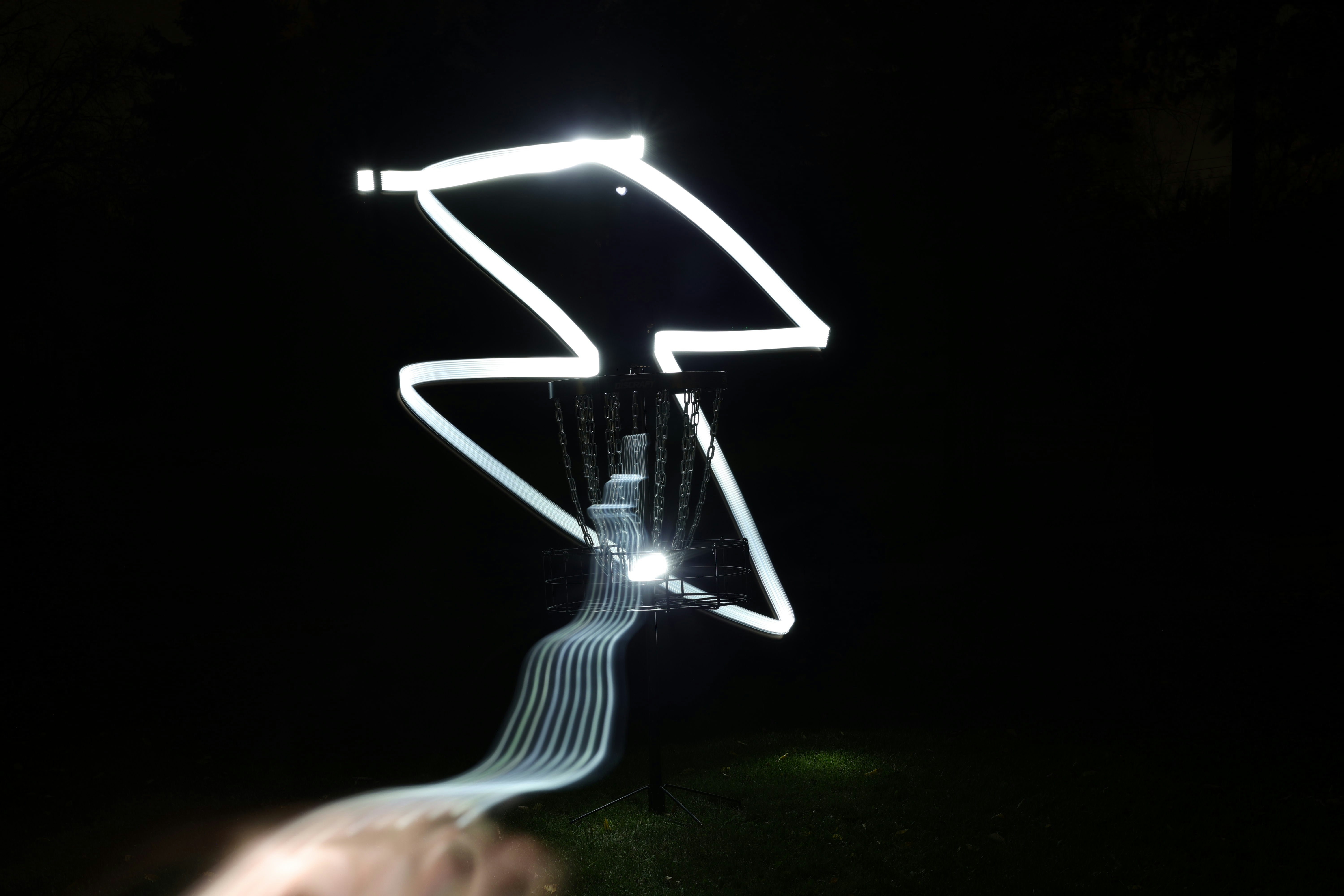 Midnight Spiral: Neon Arcs Weaving Around a Quiet Post