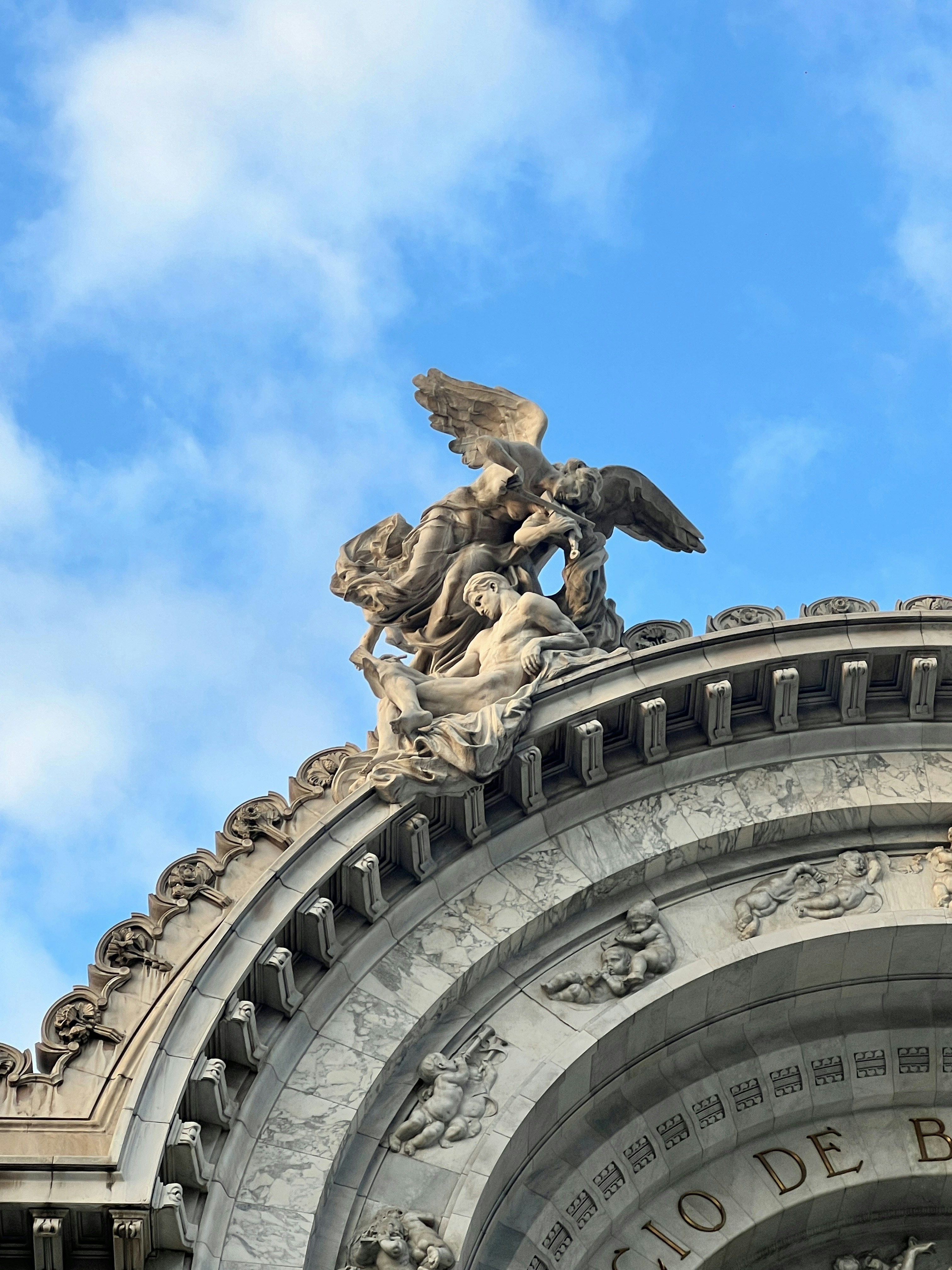 Winged Marble Ascendant Above the Arc: Statues Crowning a Neoclassical Facade
