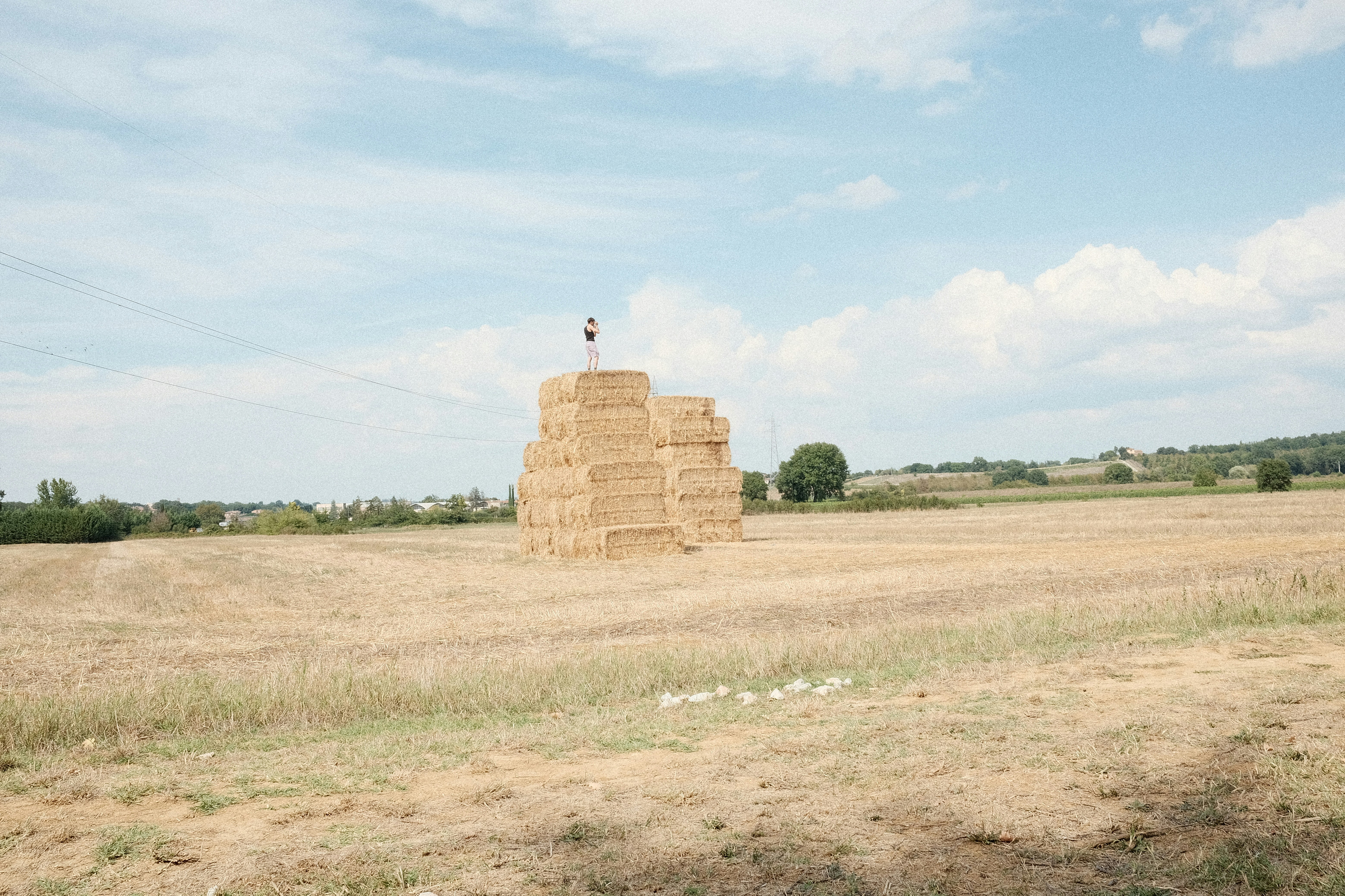 A large stack of hay sitting on top of a dry grass field photo – Free ...