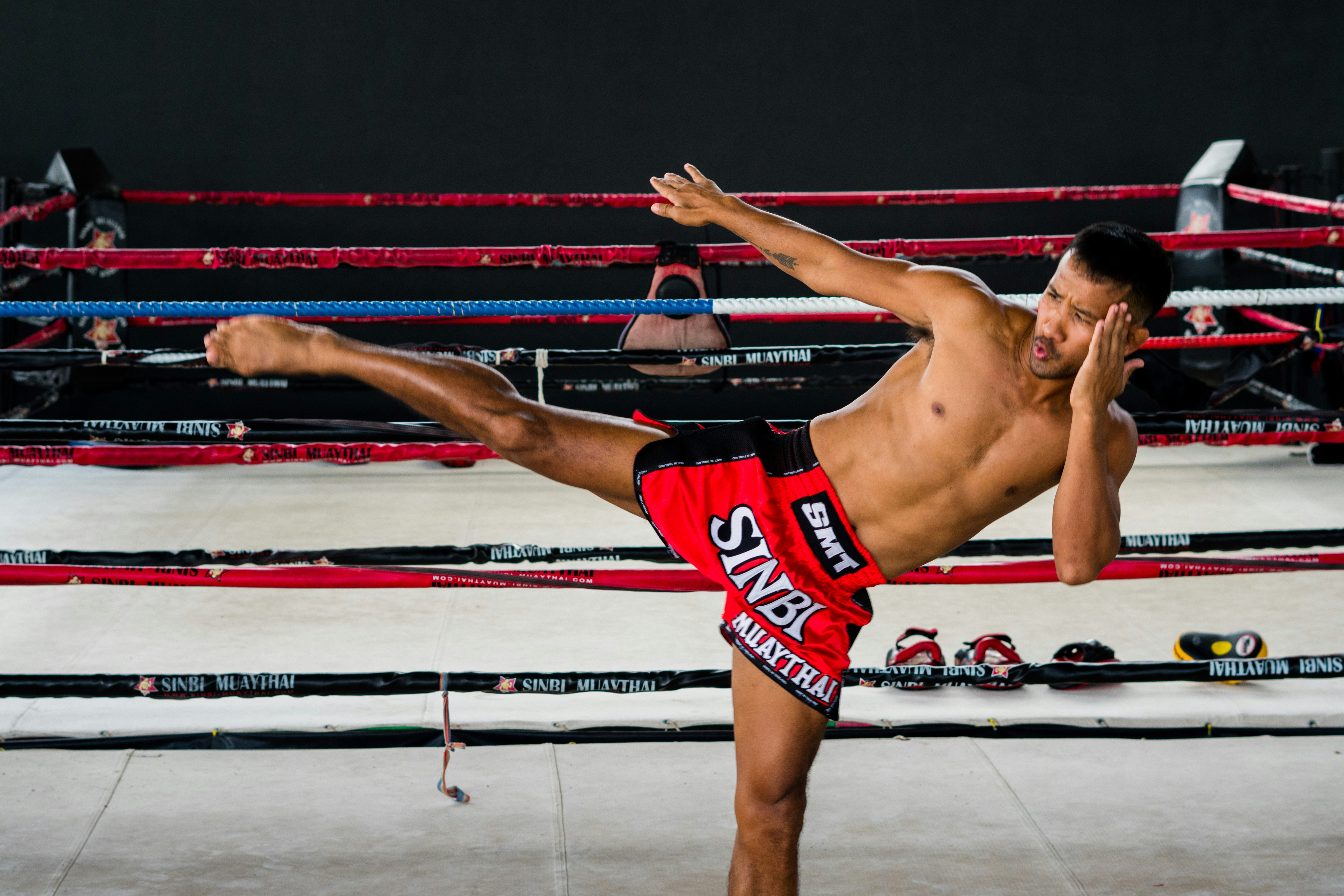 A shirtless man kicking a kick in a boxing ring photo – Free Thailand ...