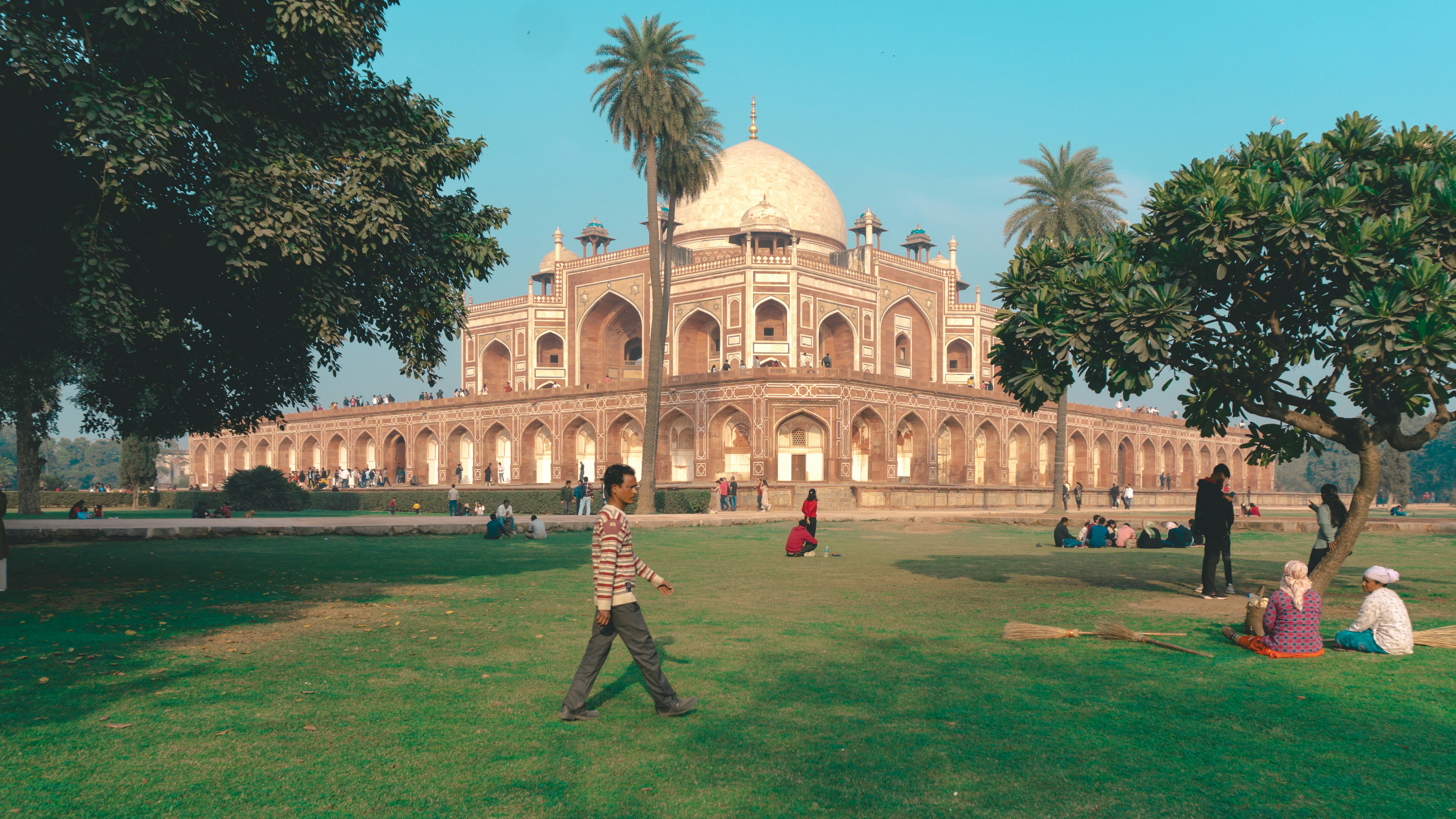 Dome in the Afternoon Light: A Mughal-Style Monument Framed by Palms and Parkgoers