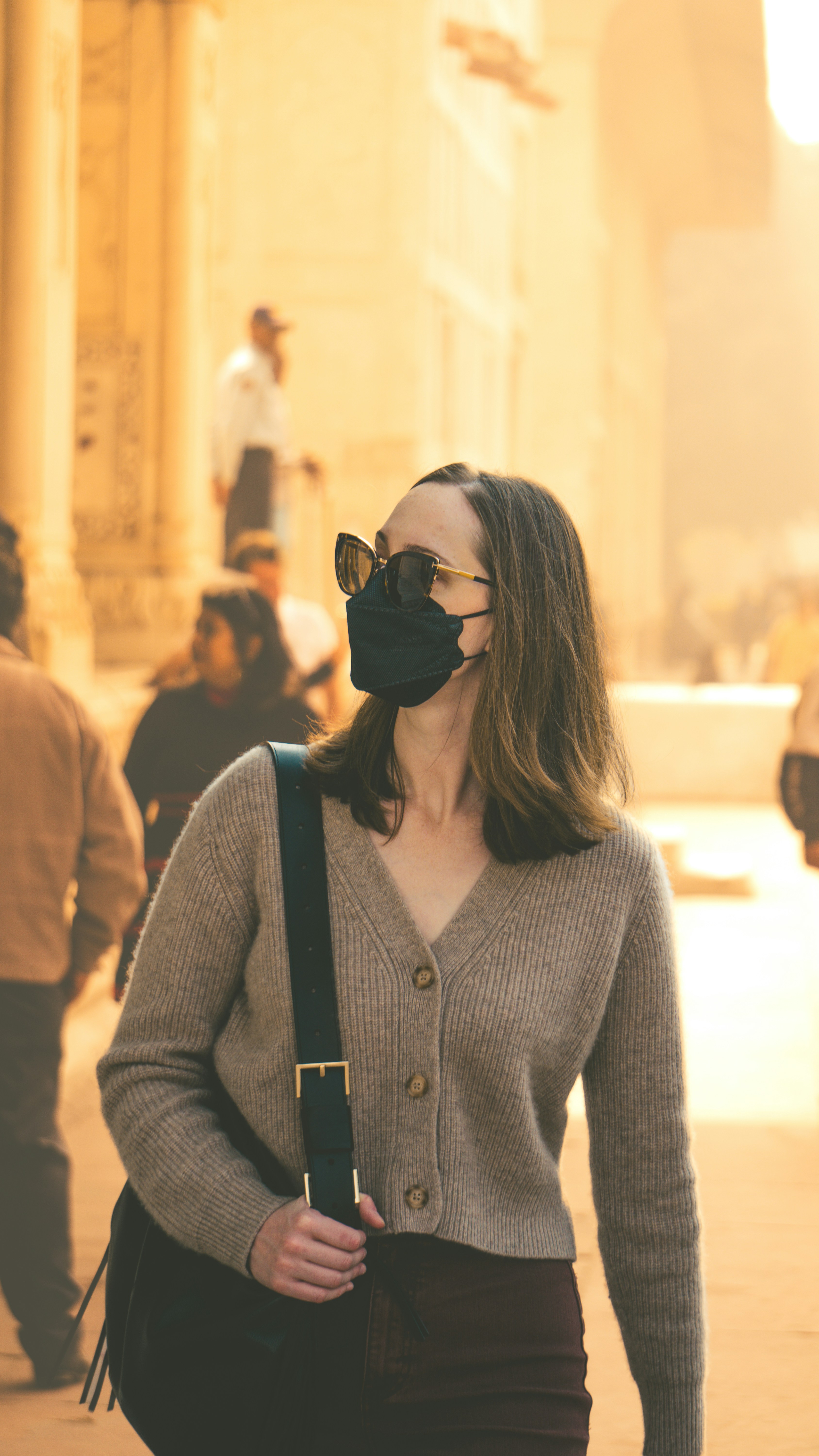 Amber Hour Portrait: A Masked Figure Steps Through a Sunlit Plaza