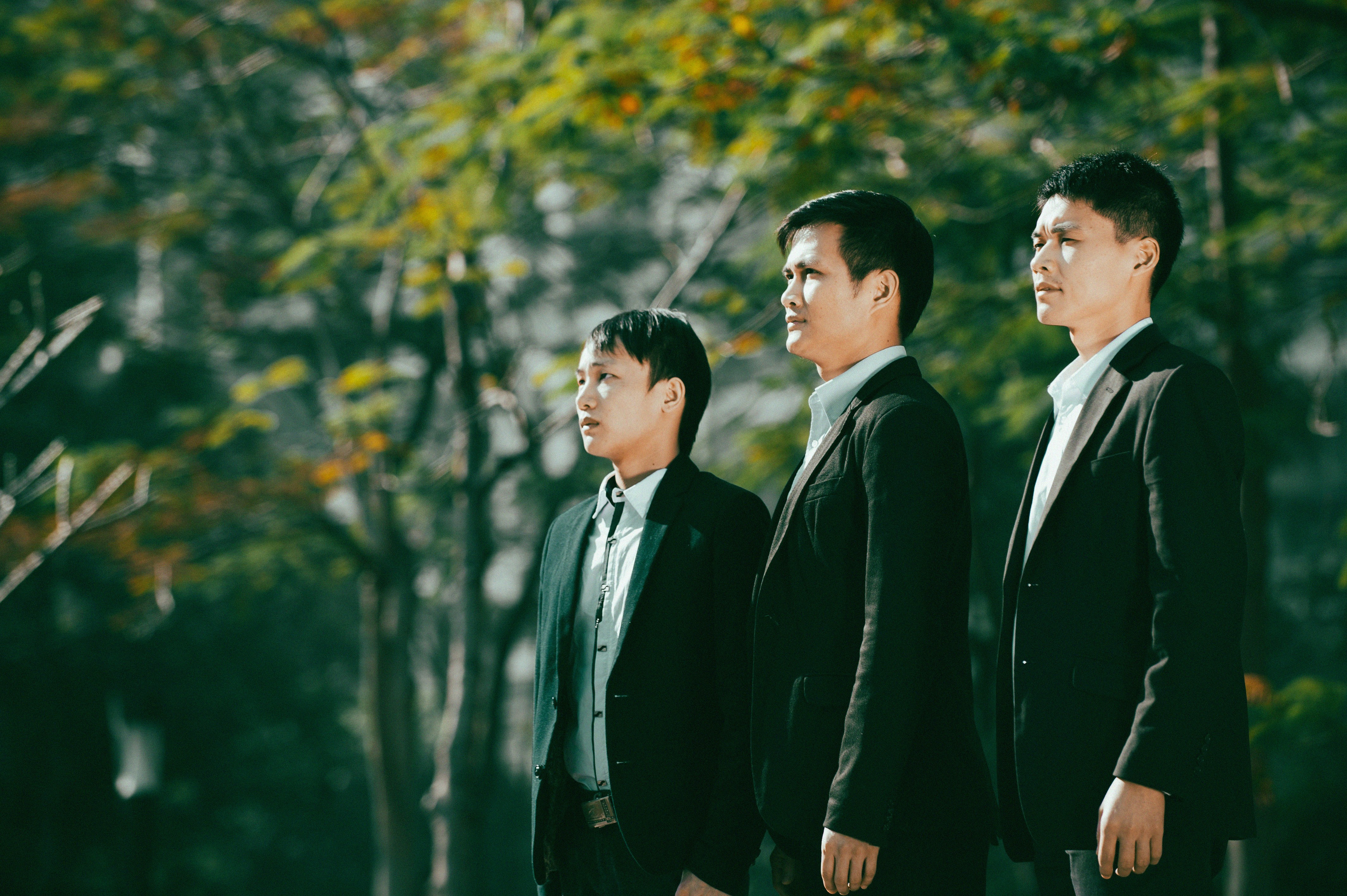 A group of three men standing next to each other photo – Free Young man ...