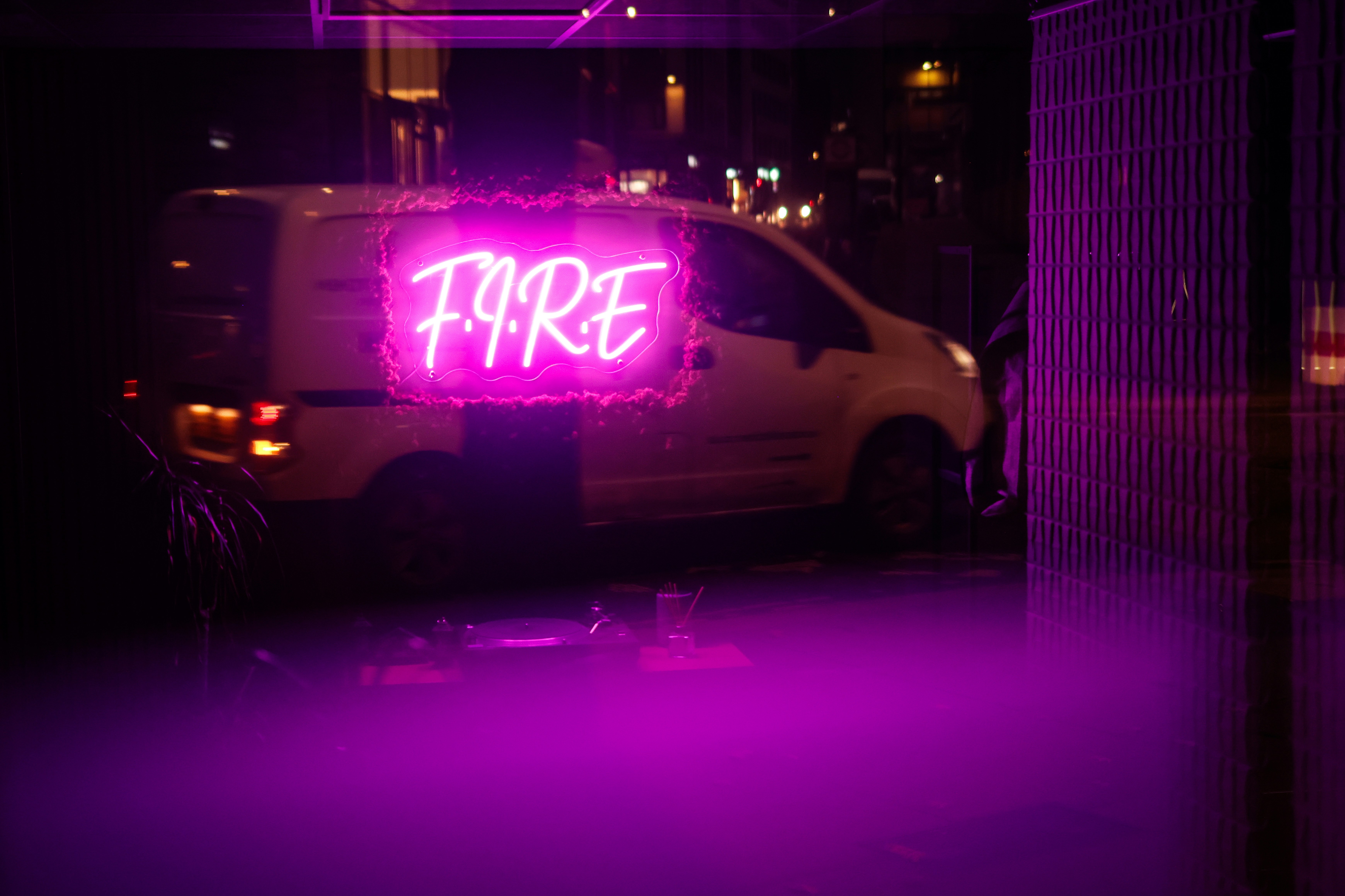 Neon Ember on Wheels: Pink FIRE Sign in a Purple Night
