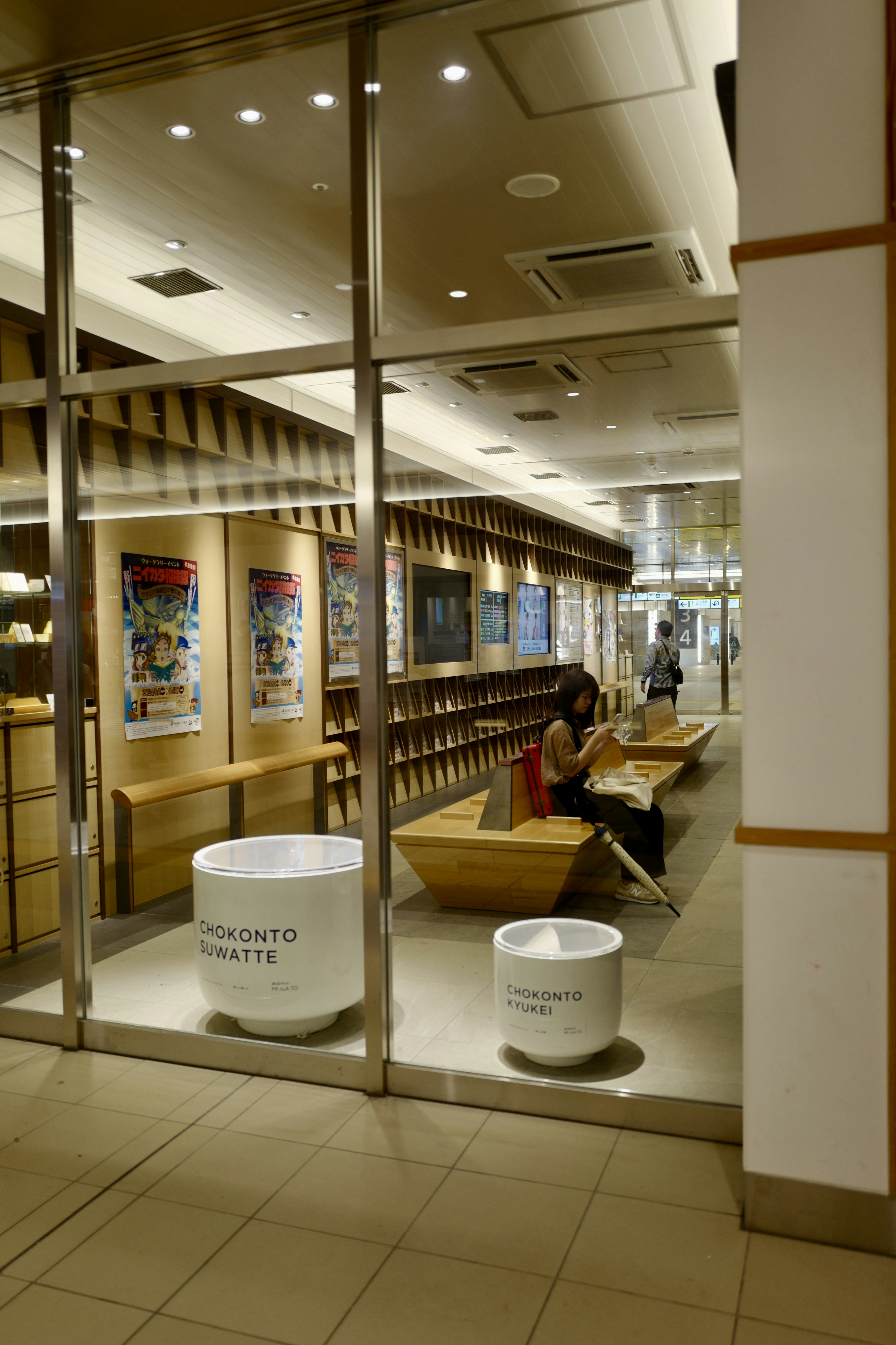 A library with a few people sitting on benches photo – Free Building ...