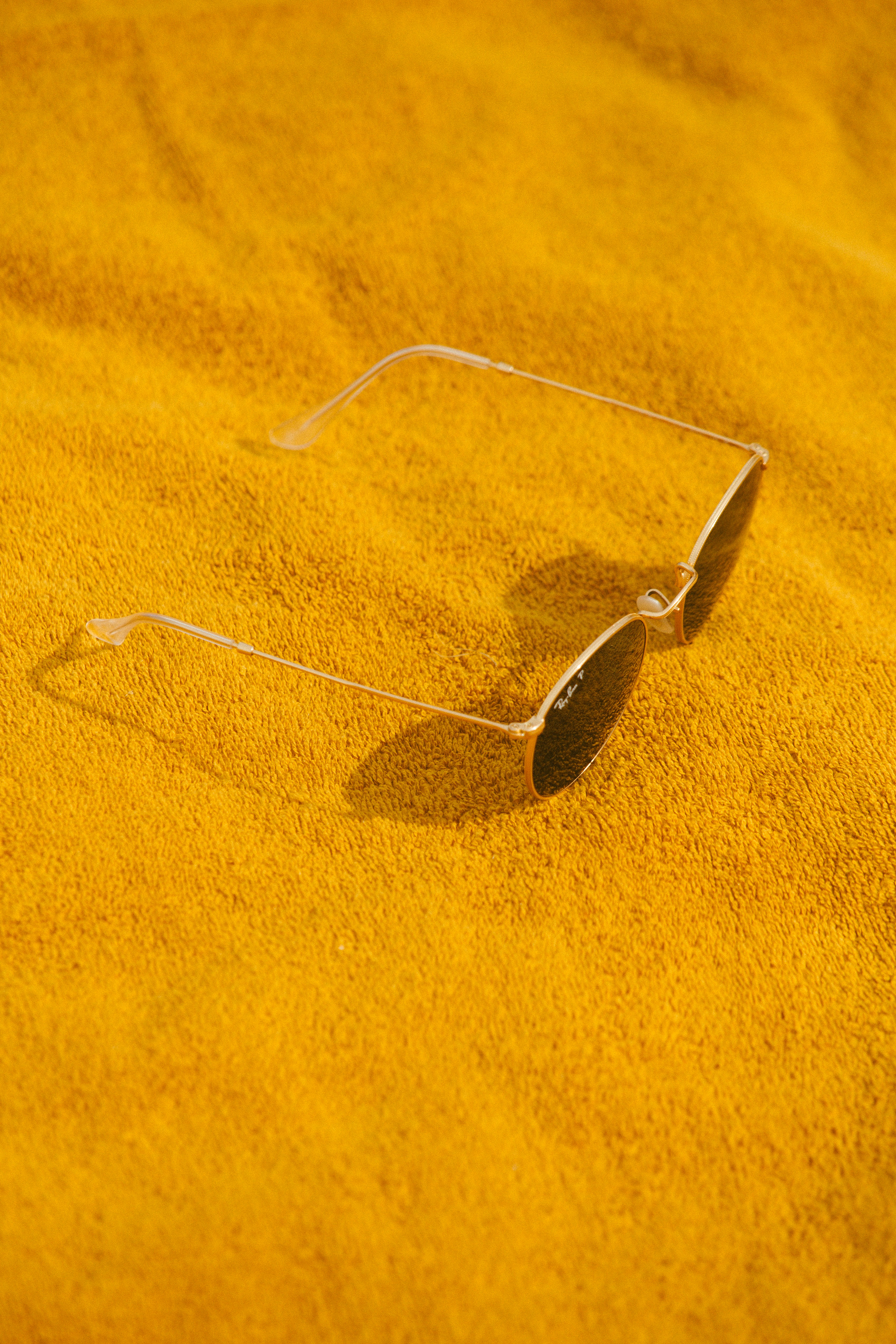 Amber Gaze: Sunglasses Lie on Sunlit Yellow Velvet