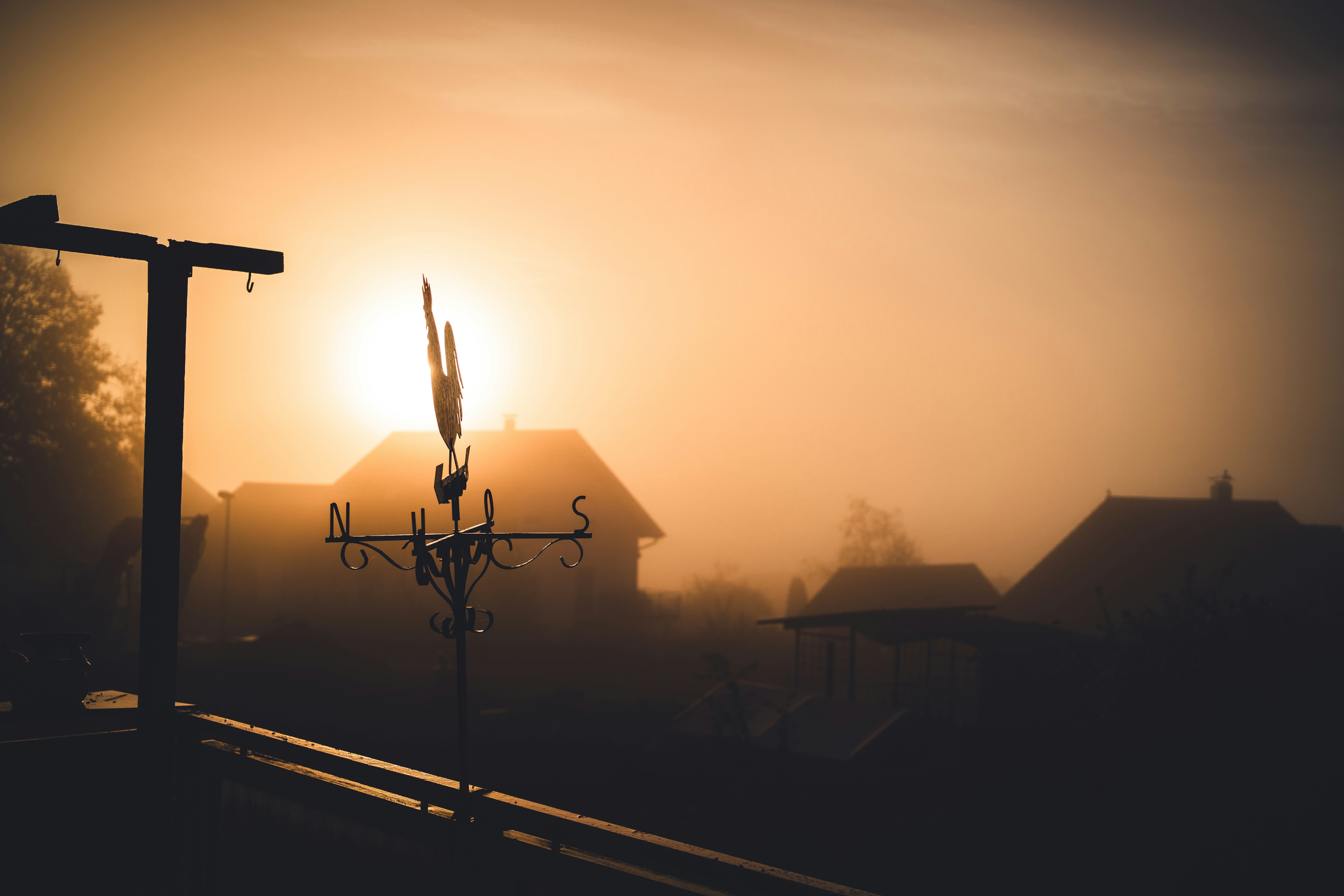 Sunrise on a Silent Rooftop: A Yellow Ball of Fog Behind the Silhouettes
