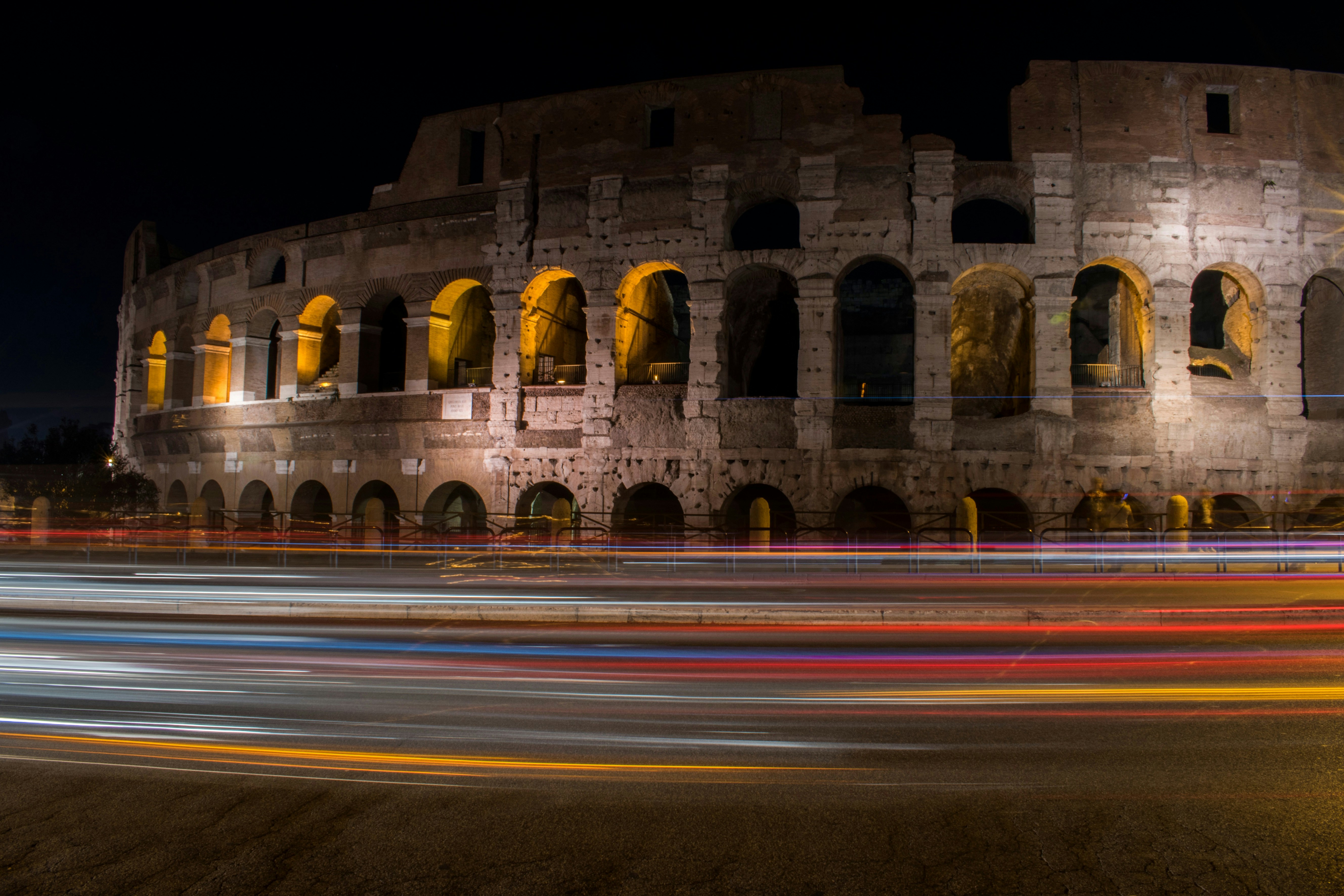 Nocturnal Arches and Neon Trails: Rome's Colosseum in Motion