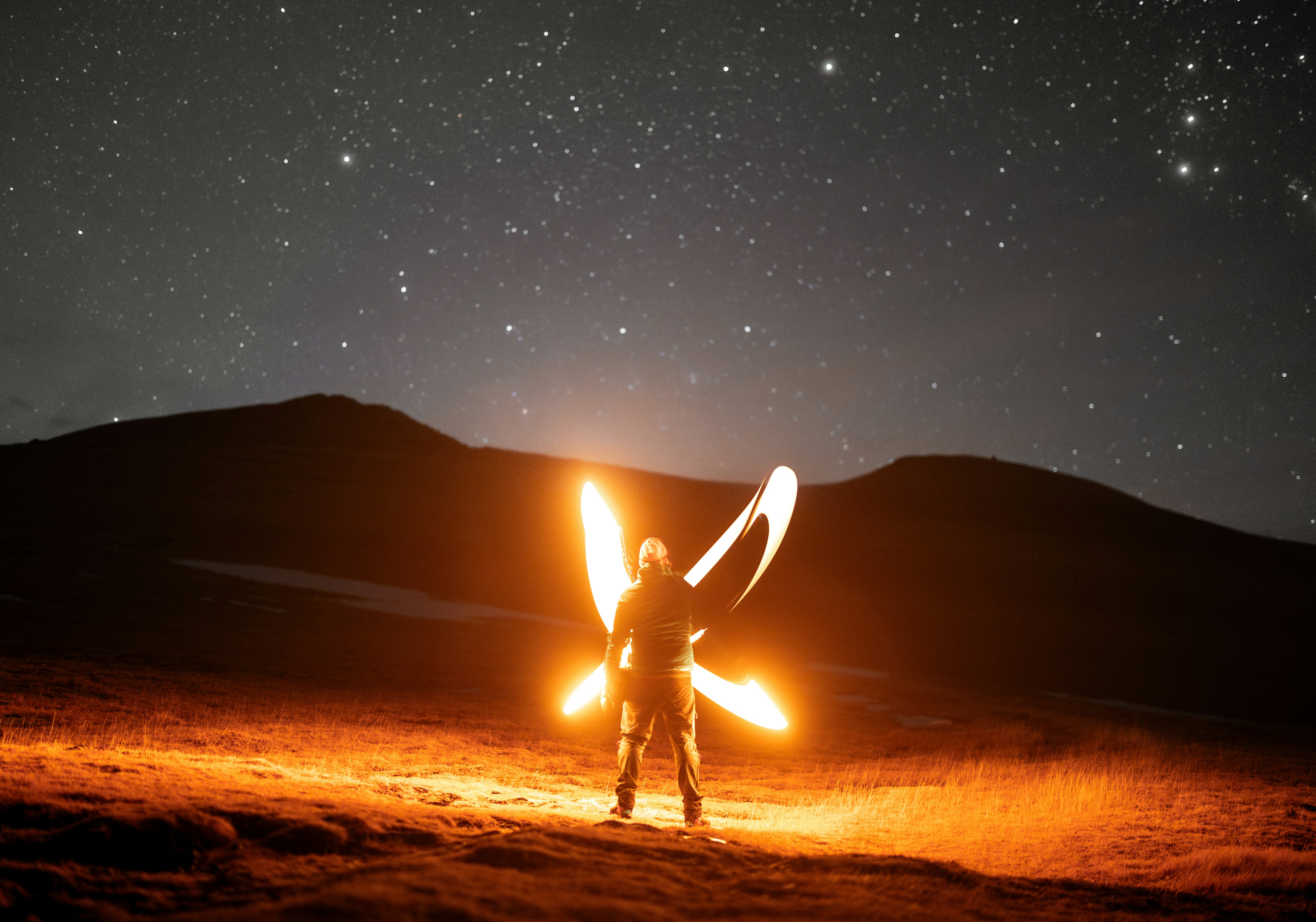 Nightfire Wings: A Lone Silhouette Paints Light Across Desert Veil