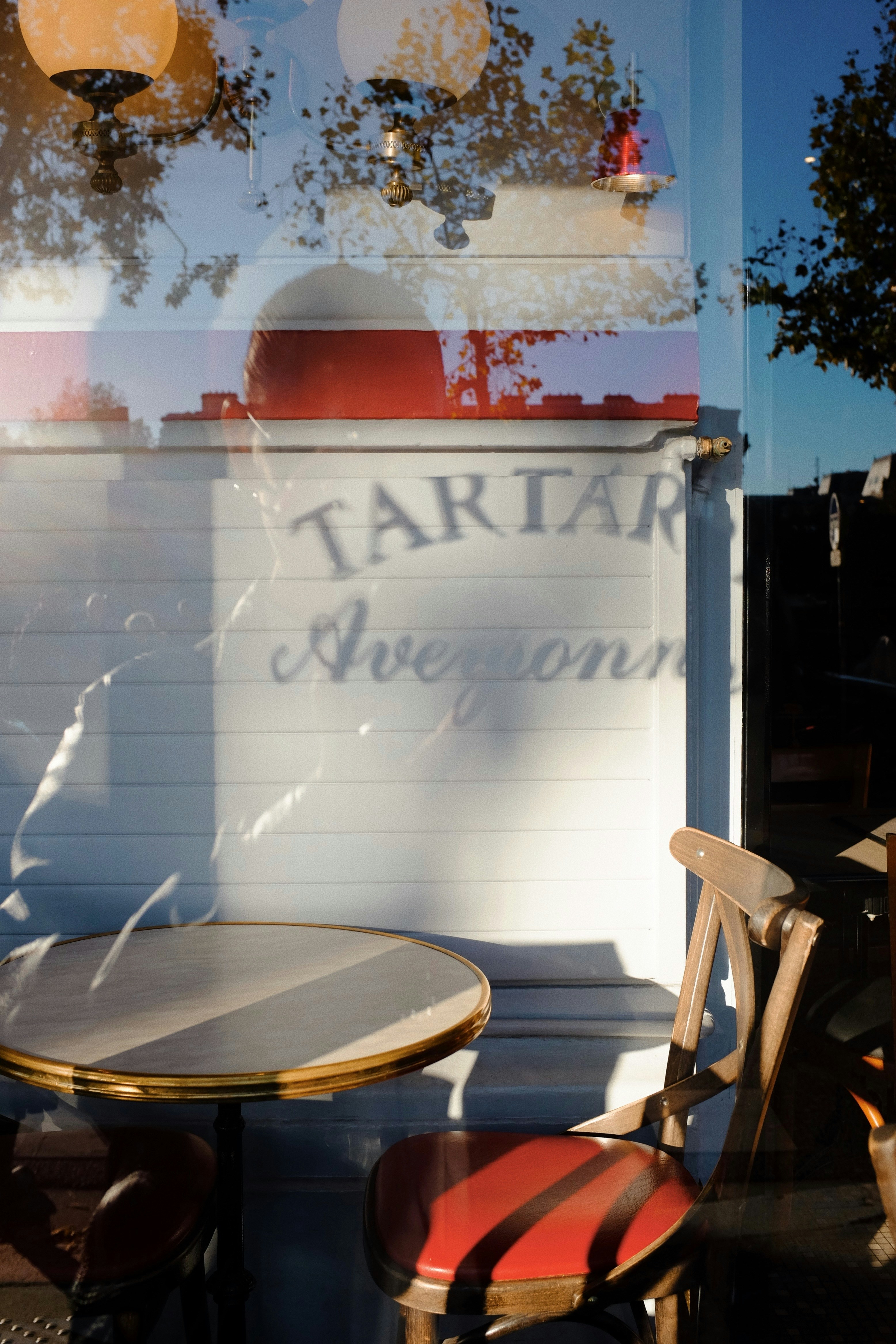 Cafe Window Reverie: Reflections on a Sunlit Terrace