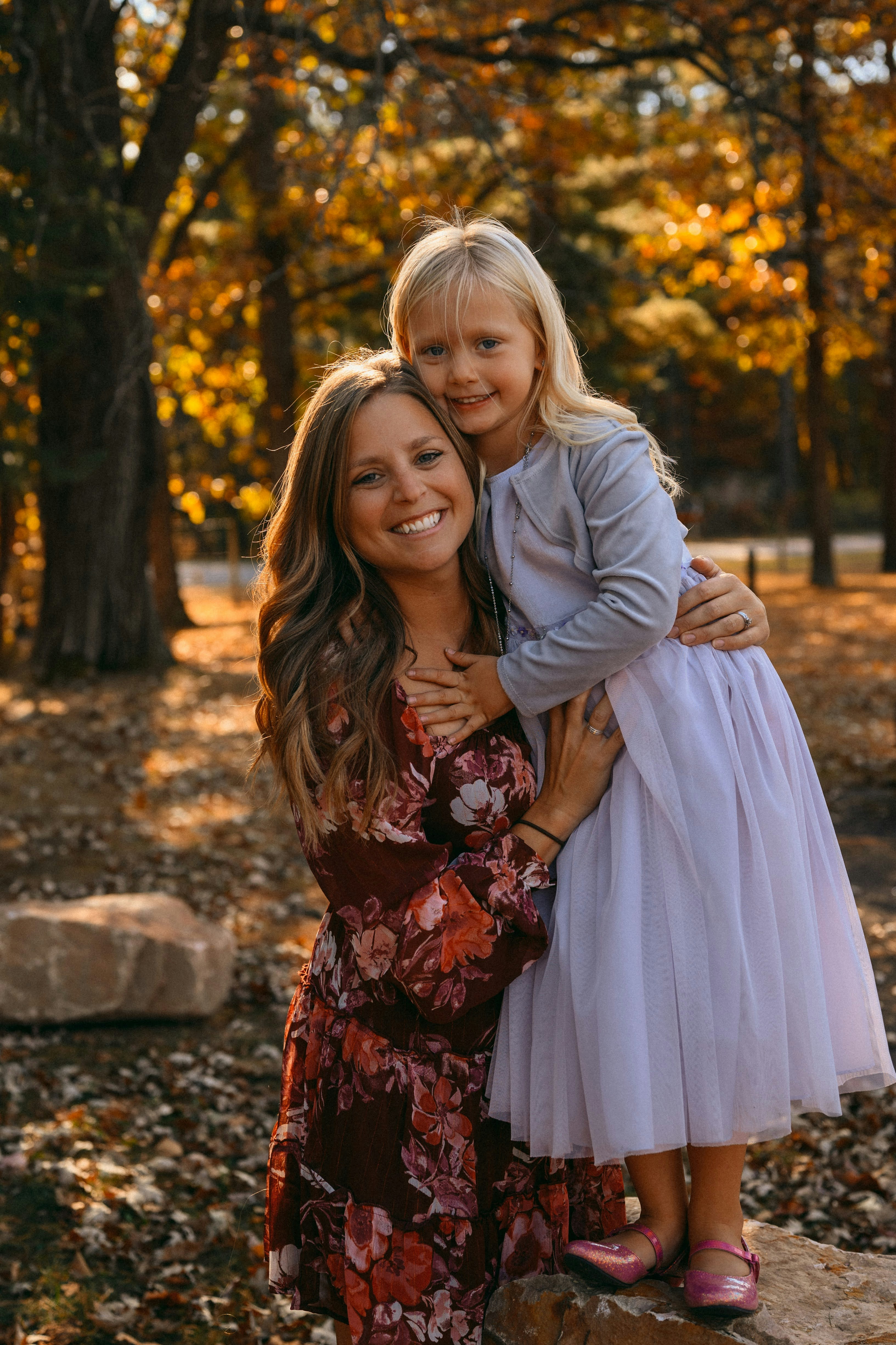 Autumn Glow: A Mother-Daughter Hug Beneath Amber Canopy