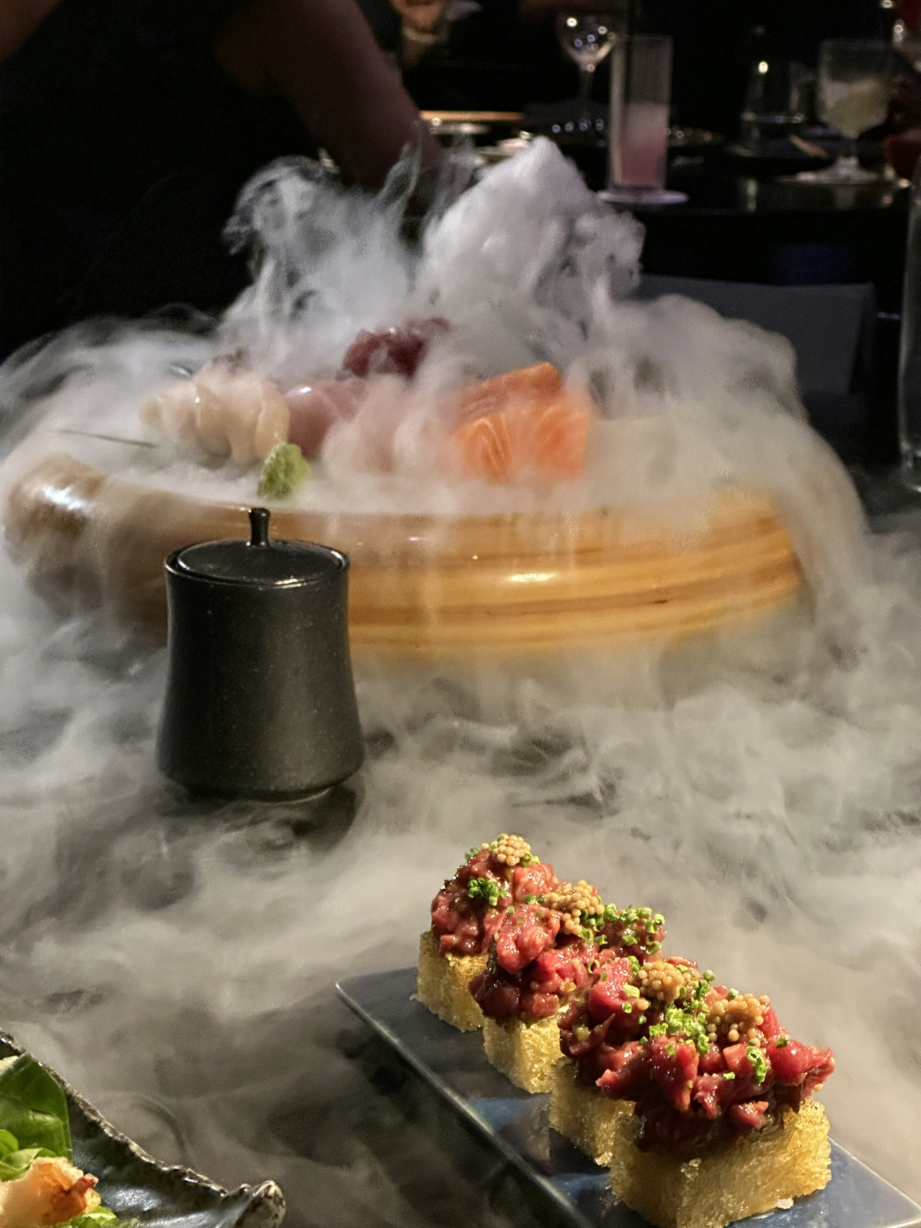 A table topped with a plate of food covered in smoke photo – Free Food ...