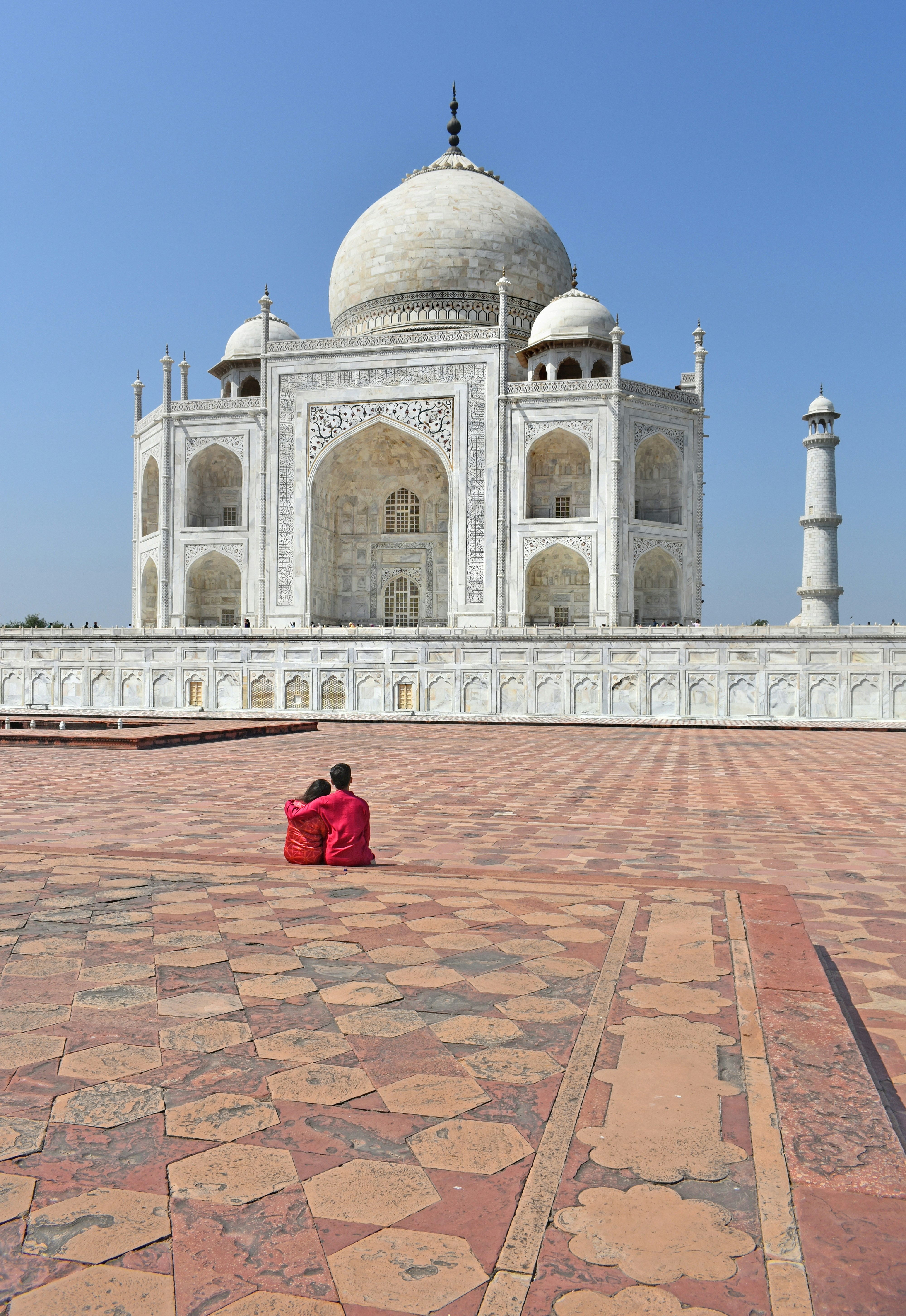 Red Cloak, White Dome: A Quiet Moment at the Taj Mahal Forecourt