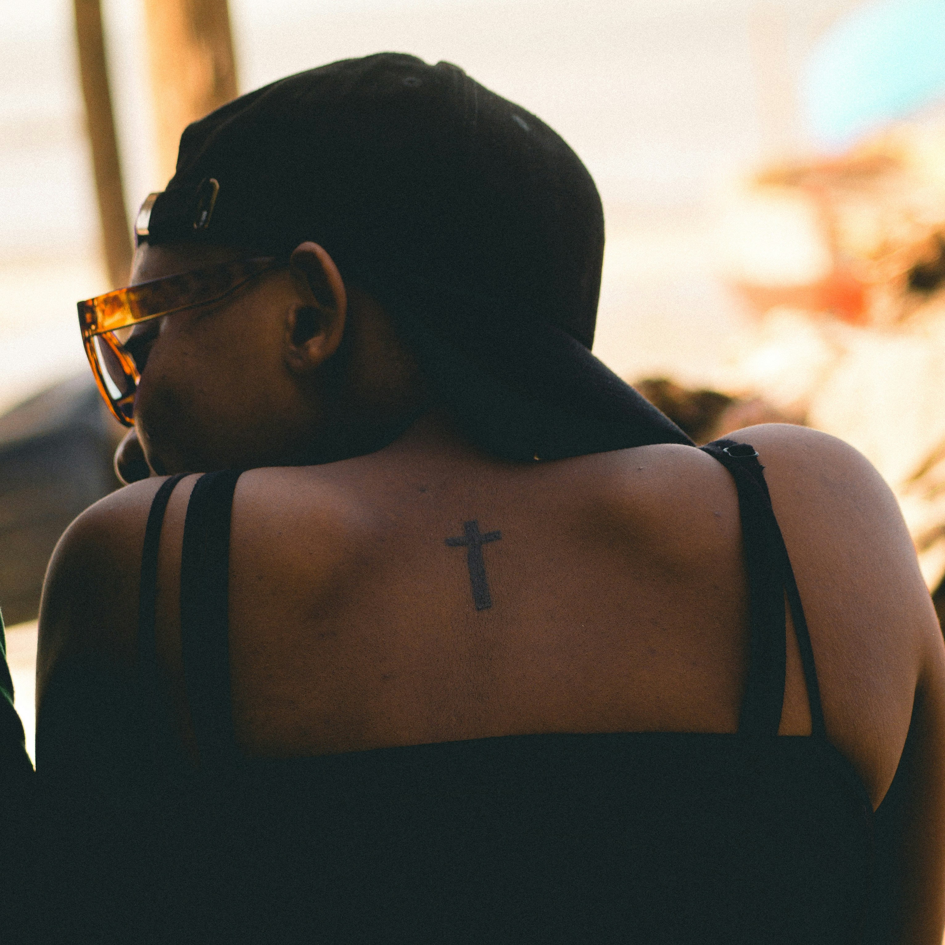 Cross Tattoo in Amber Streetlight: A Quiet Back Portrait