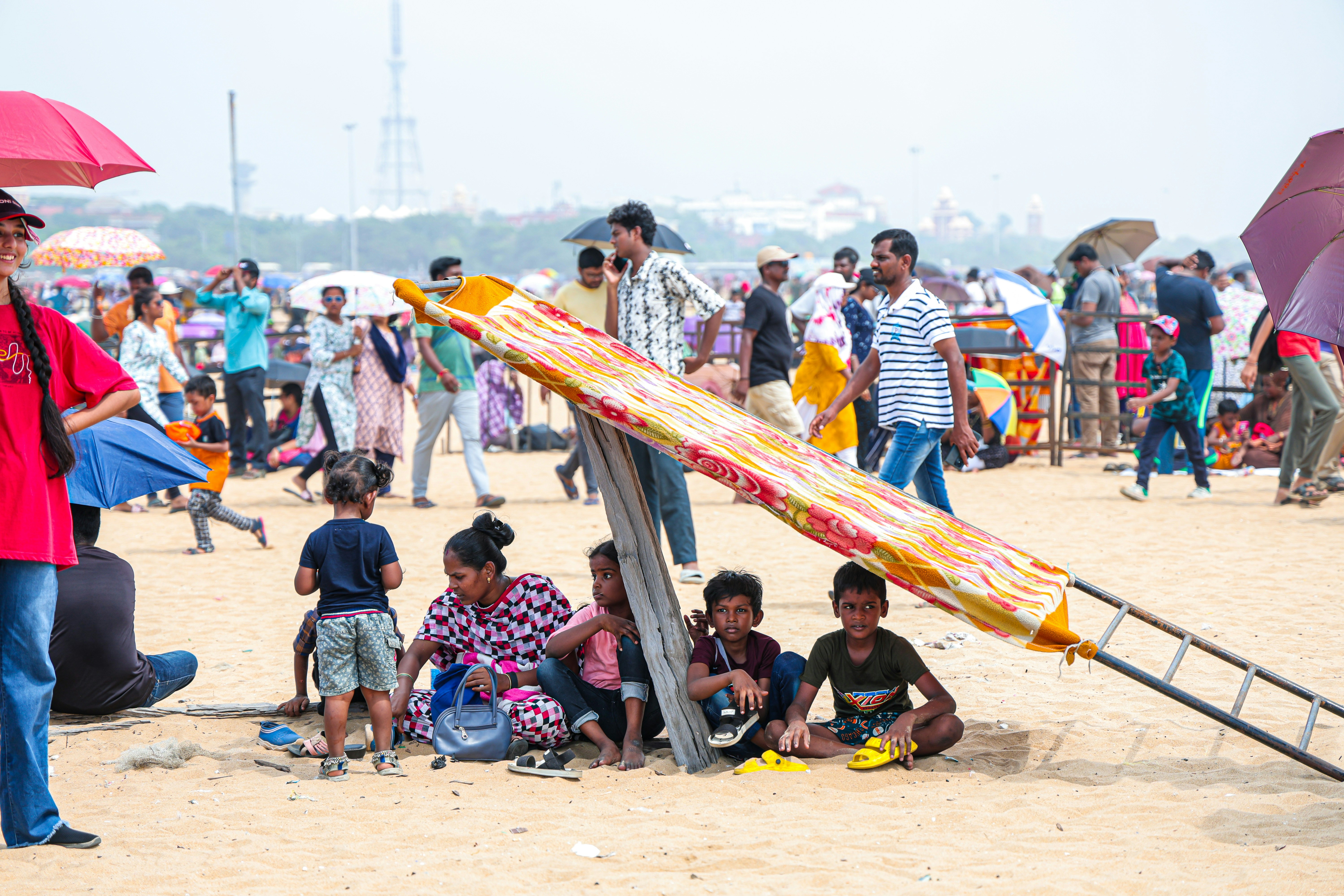 A group of people sitting on top of a sandy beach photo – Free Beach ...