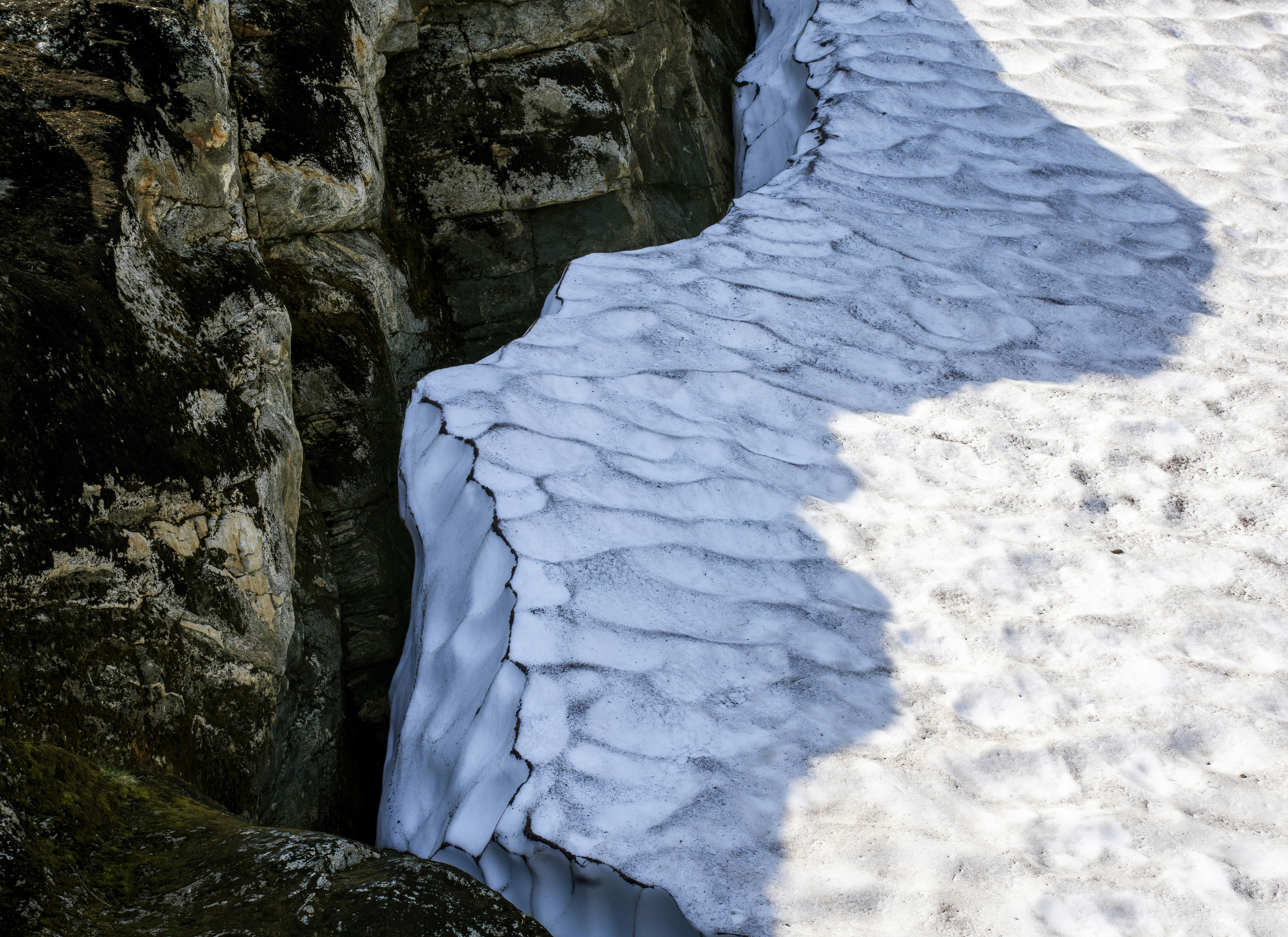 Ice Edge Convergence: Snow-Rimmed Cliff Against Rugged Rock