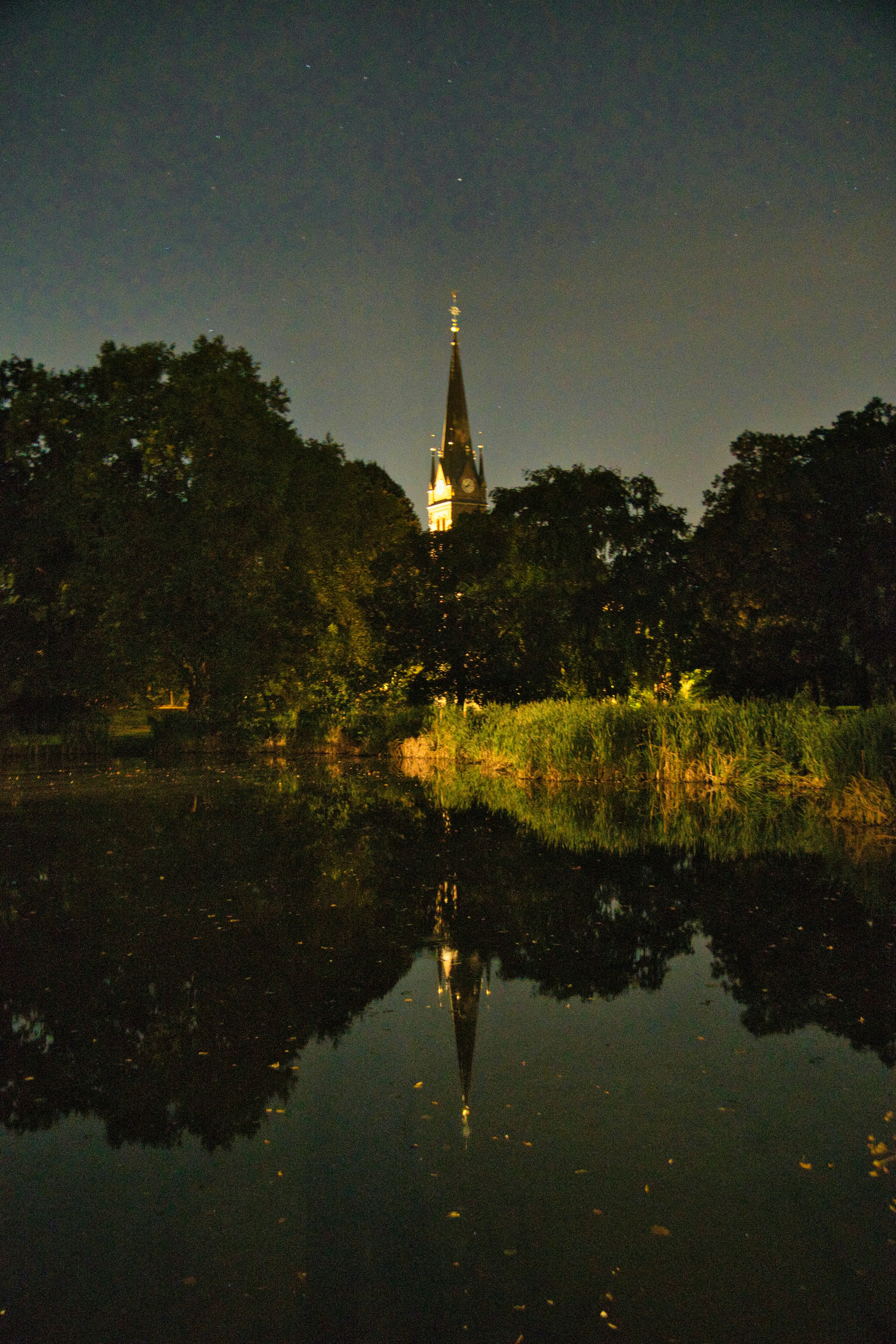 Moonlit Spire over Still Waters: Nighttime Church Reflected in the Lake