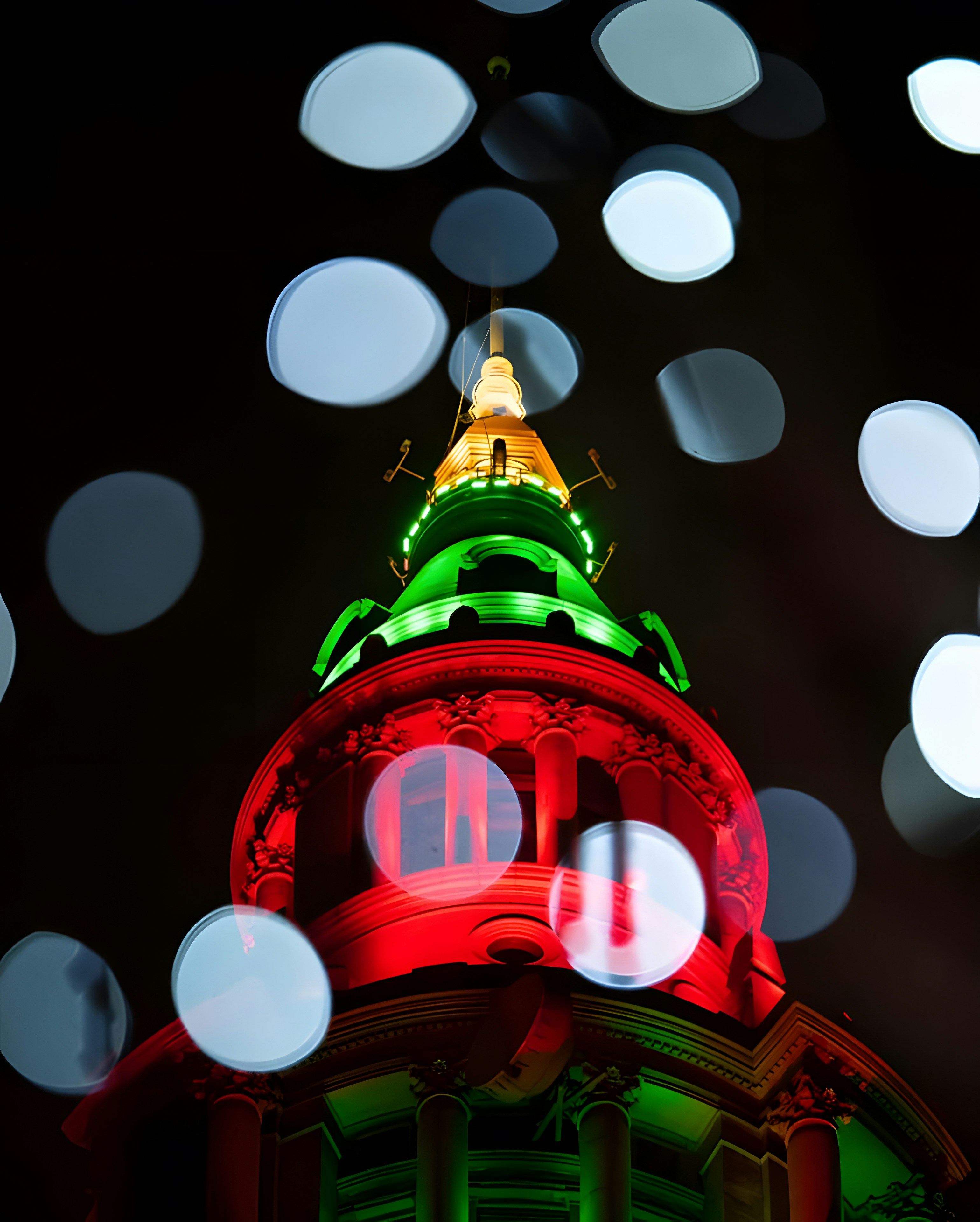 A red and green clock tower lit up at night photo – Free Lighting Image ...