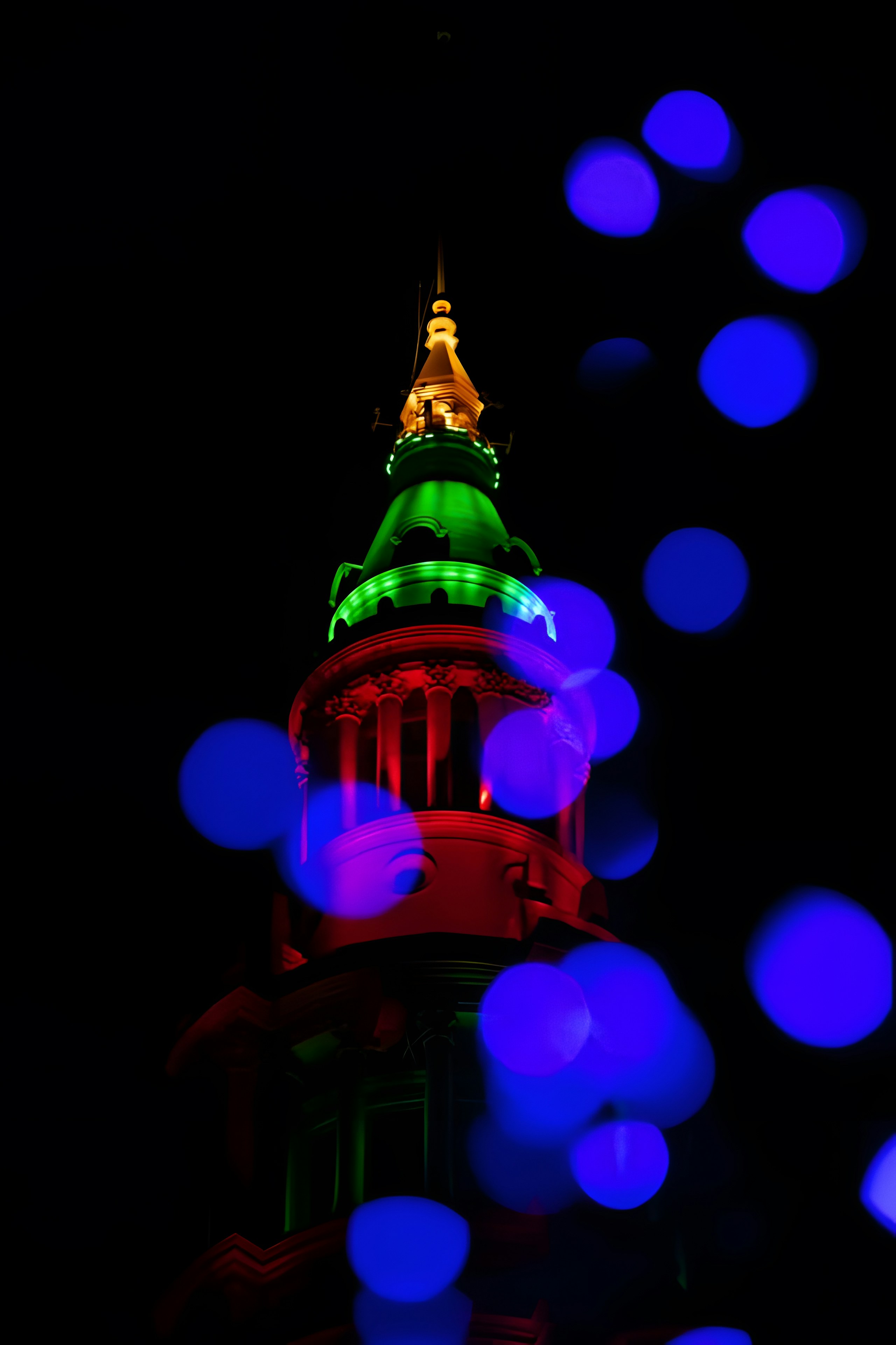A very tall building with a lit up tower at night photo – Free Lighting ...