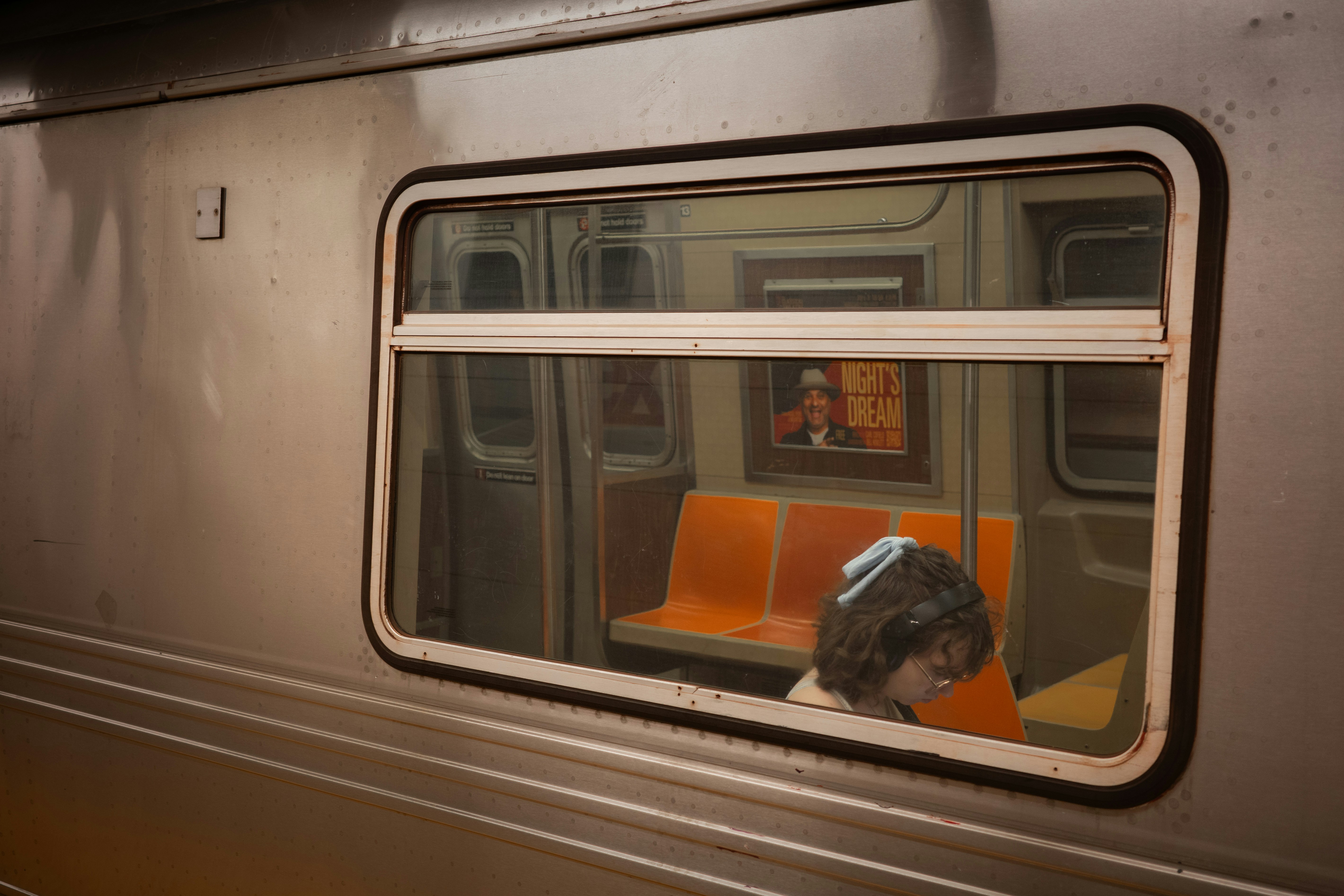 Subway Window Portrait: Quiet Focus Behind Chrome
