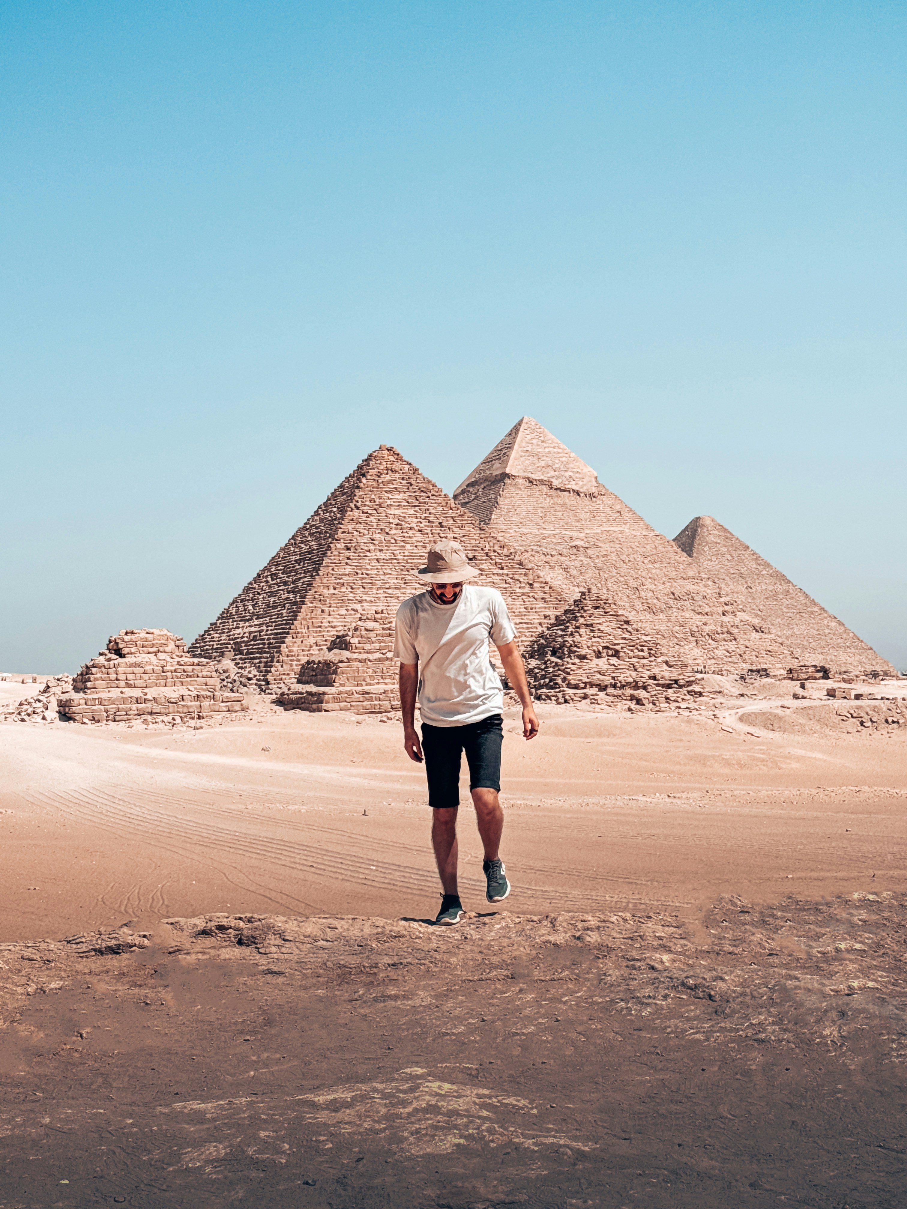 A man walking in front of the pyramids of giza photo – Free Egypt Image ...