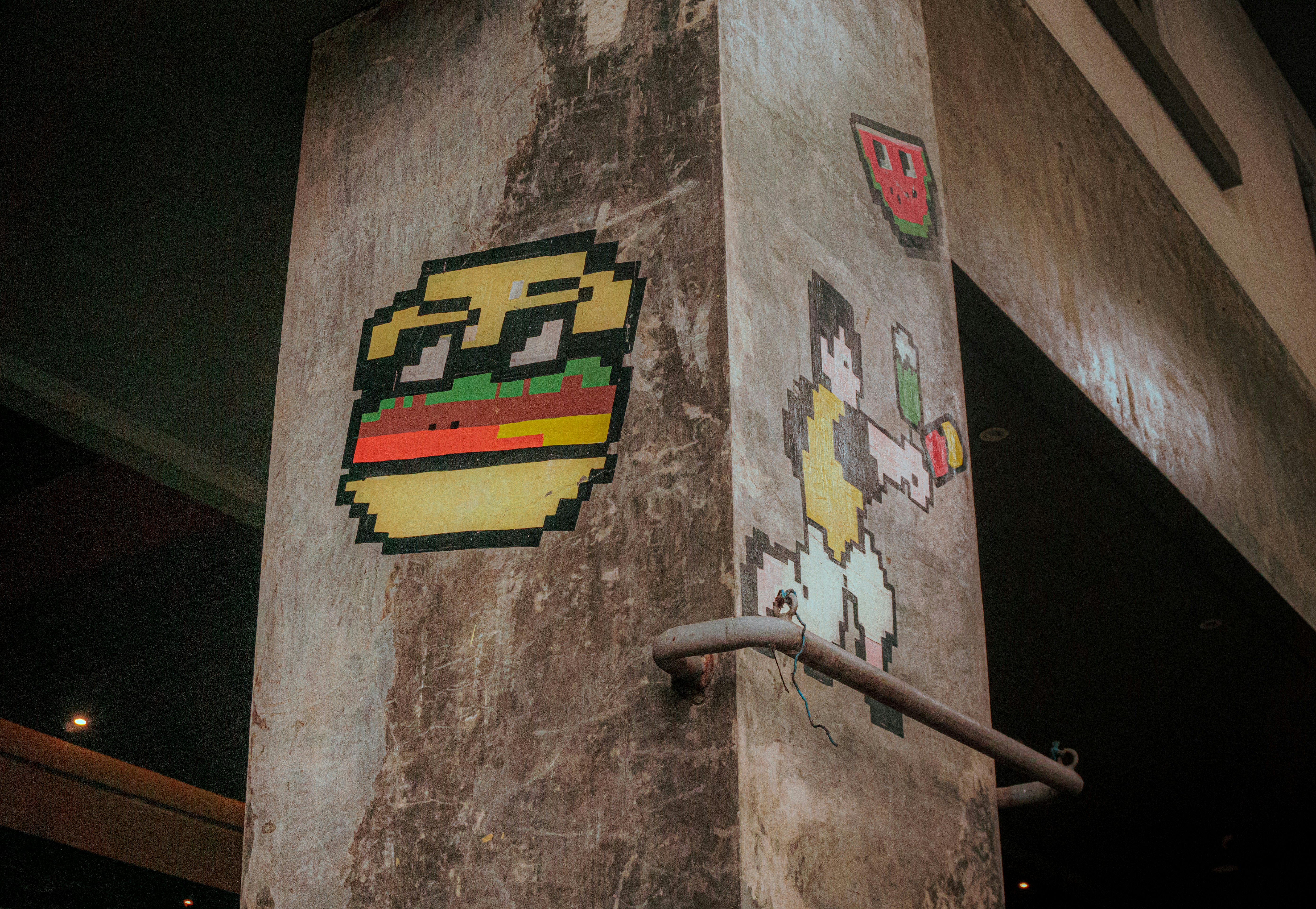 Pixel Pulse on a Weathered Column: Burger Emoji Meets Gardener