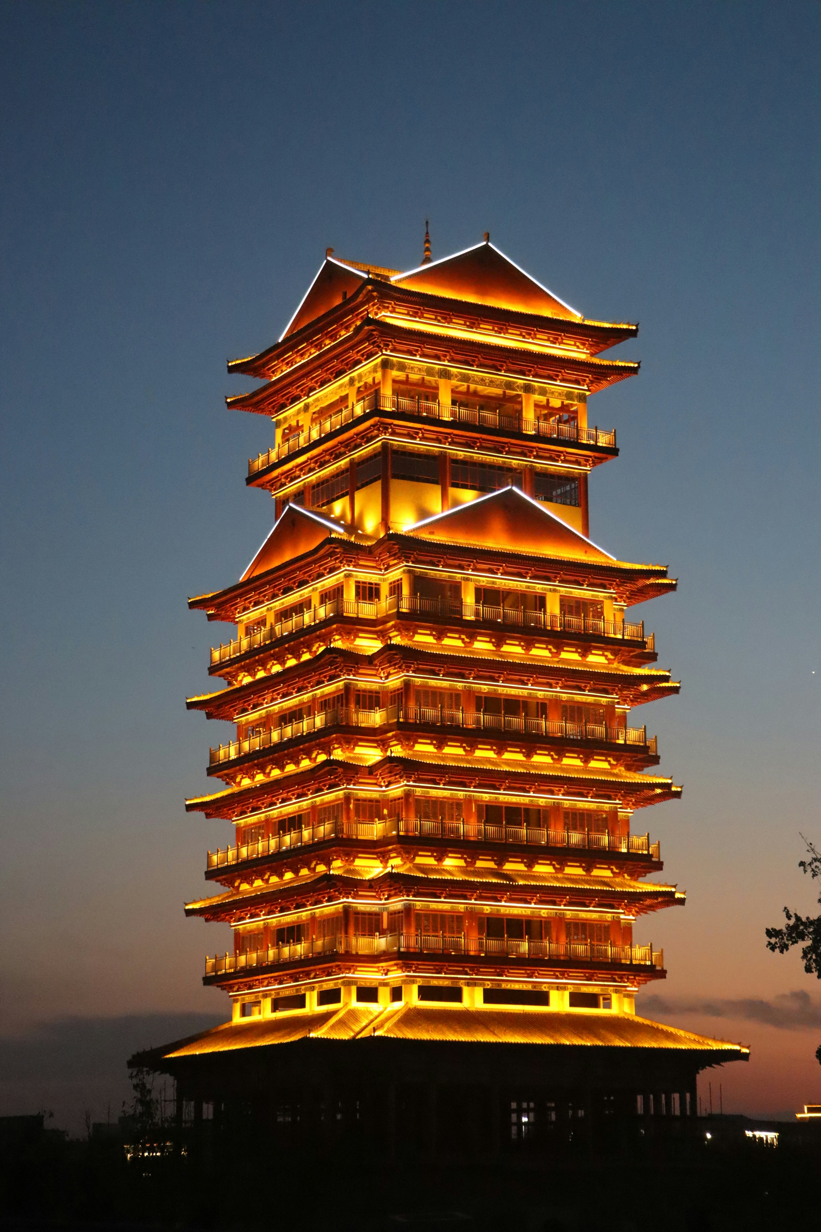 A tall tower lit up at night with lights on it photo – Free Building ...