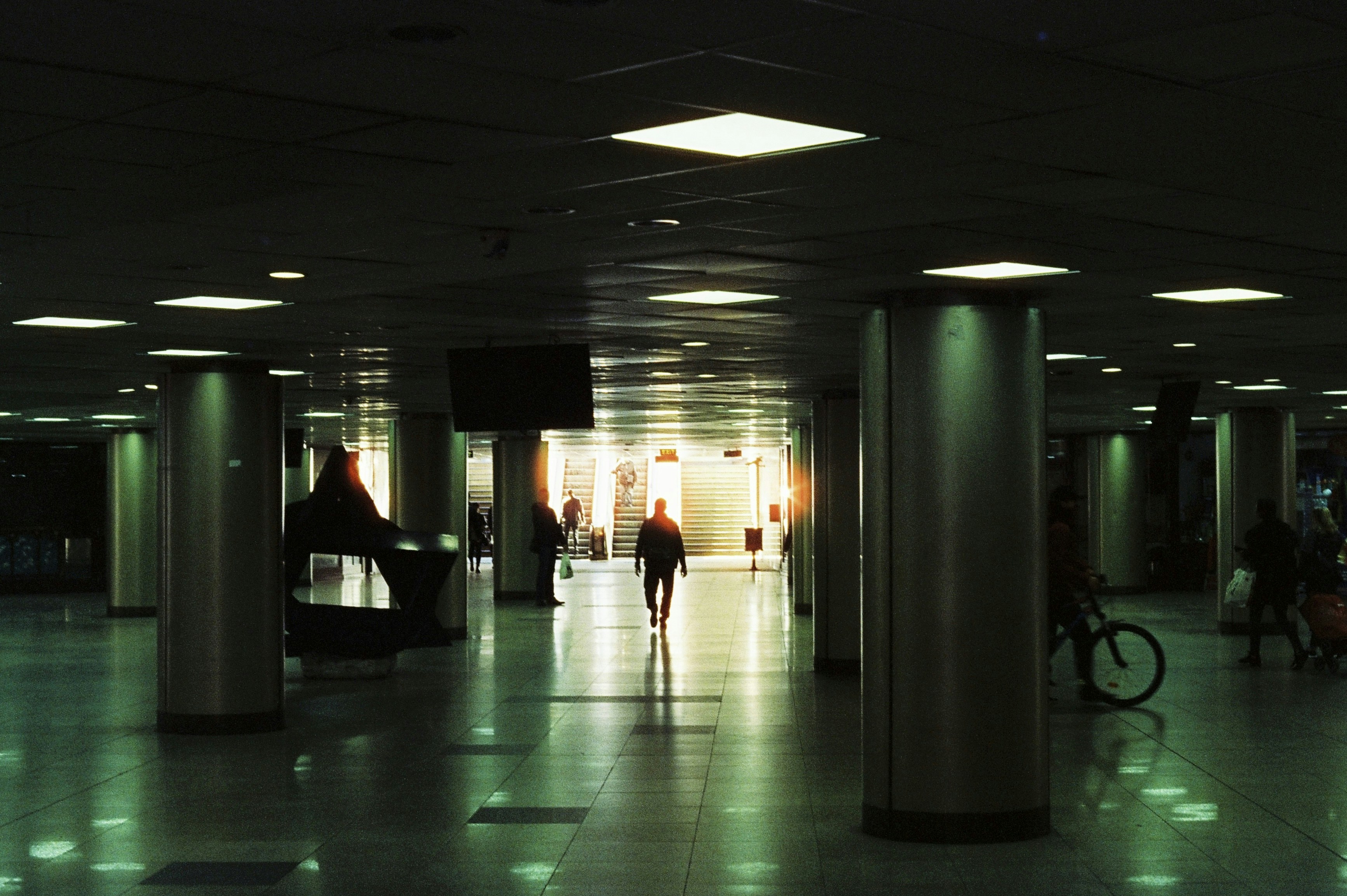 A person is walking through a dimly lit building photo – Free Analog ...