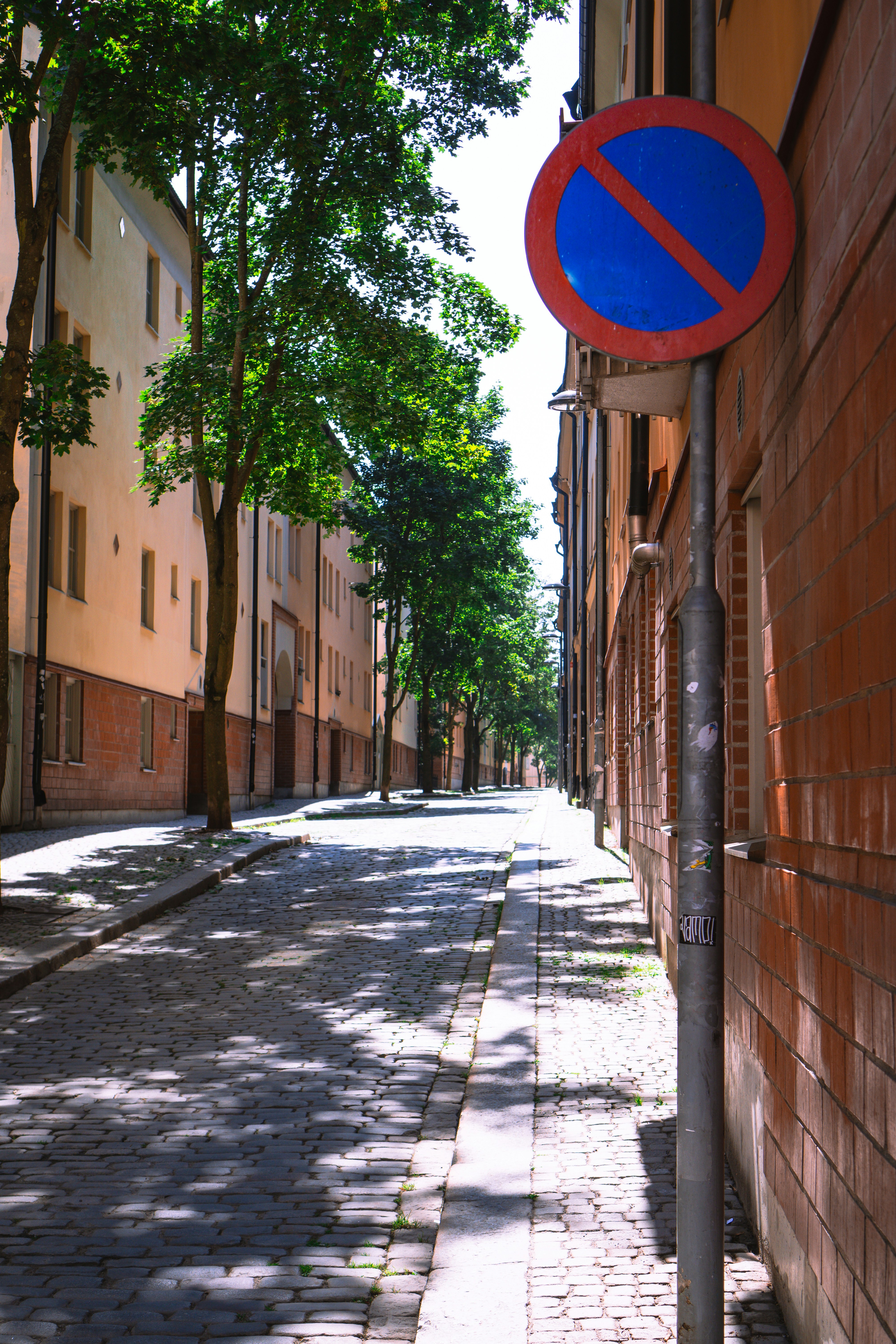 A blue and red street sign sitting on the side of a building photo ...