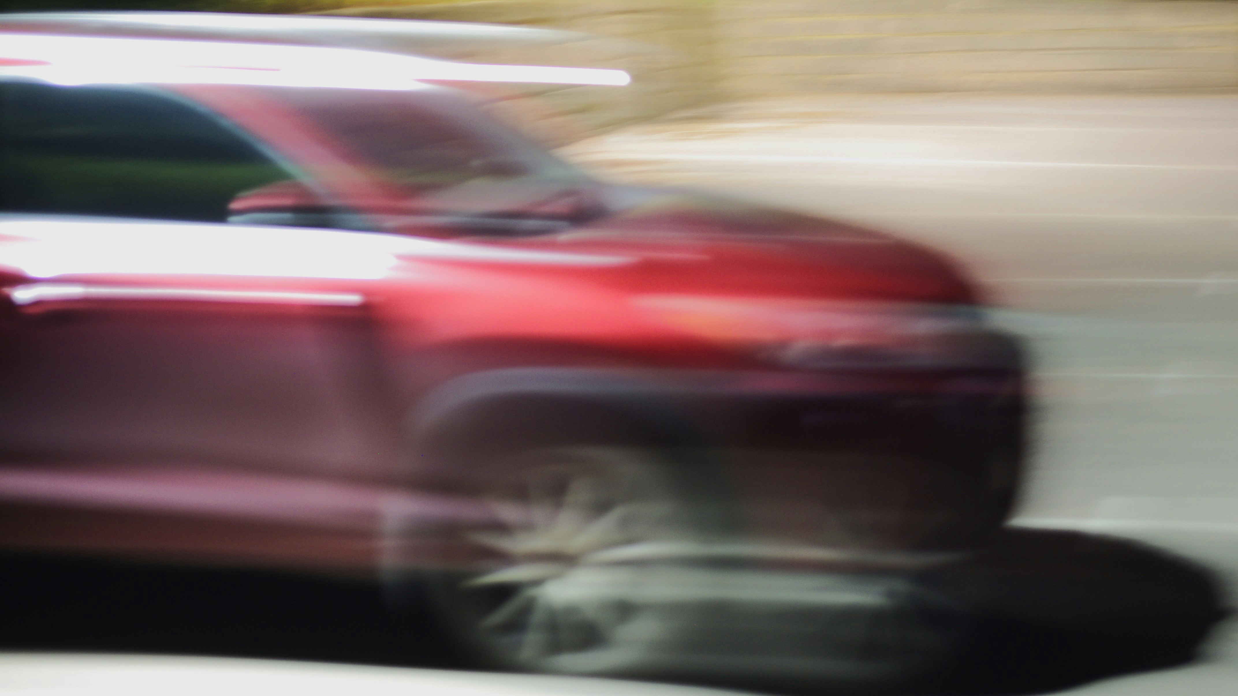 Crimson Streak: A Red Car in Motion Blur