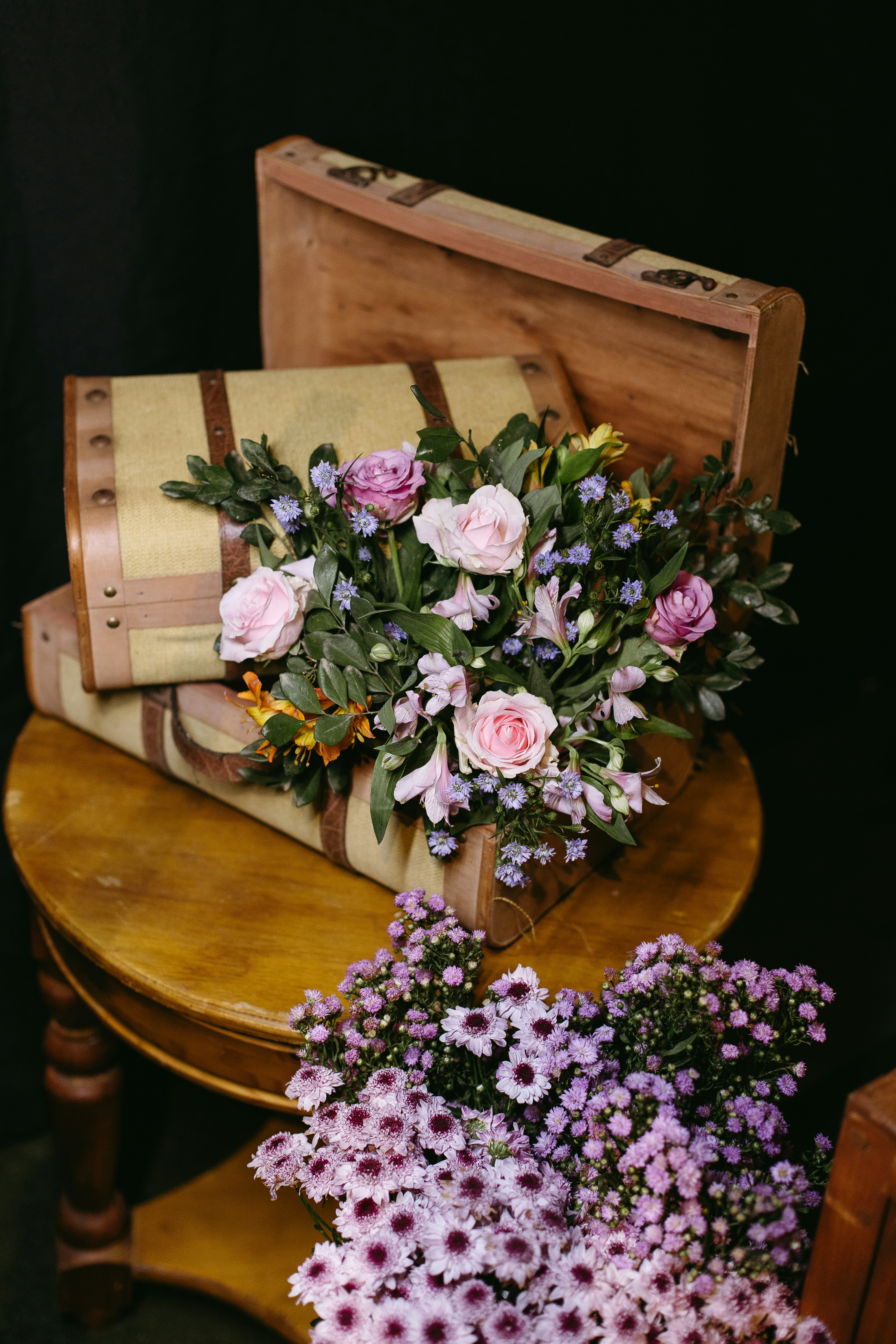 Pastel Bouquets Nest in Vintage Trunks on a Round Table