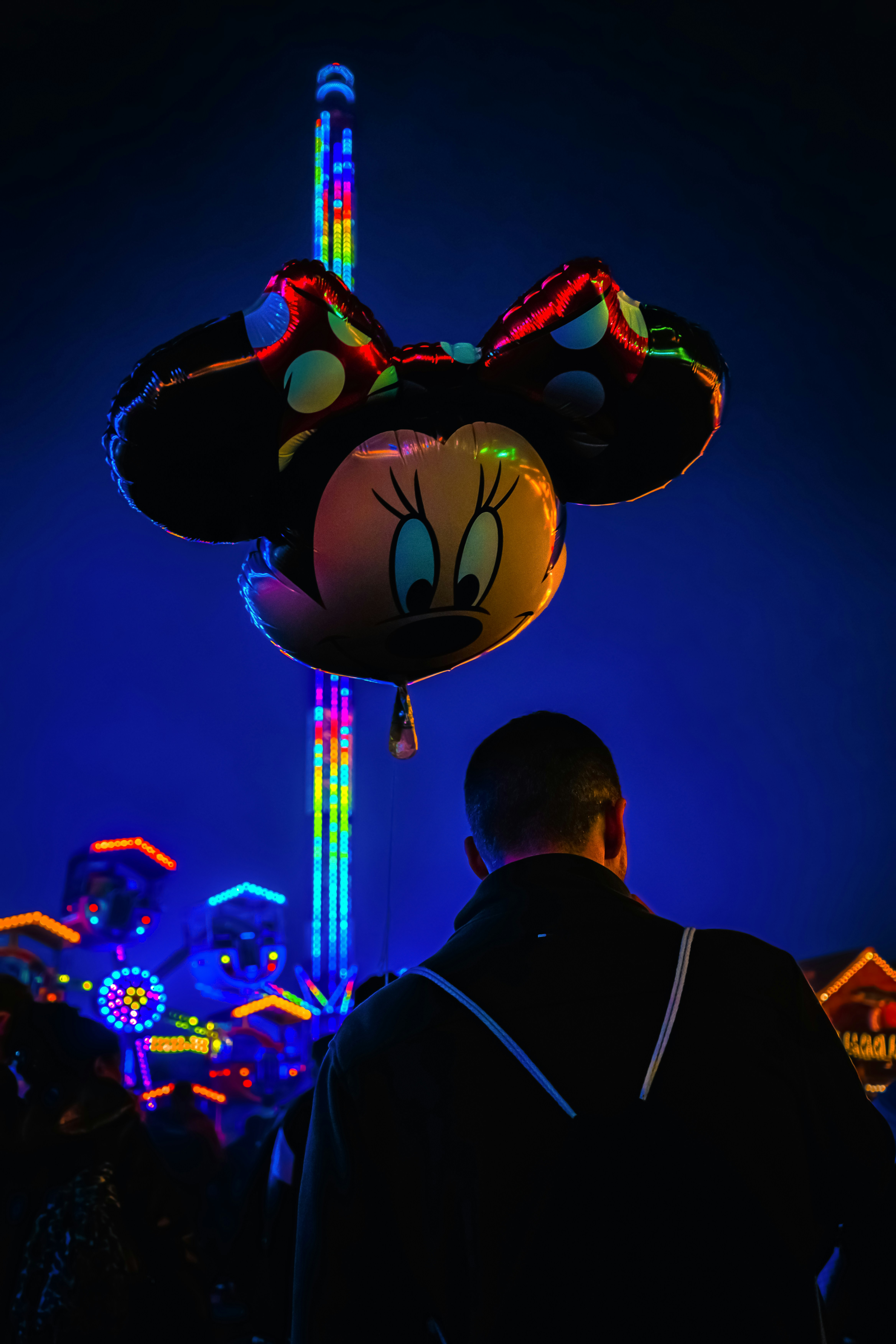 Neon Minnie Balloon Over a Night-Glow Carnival
