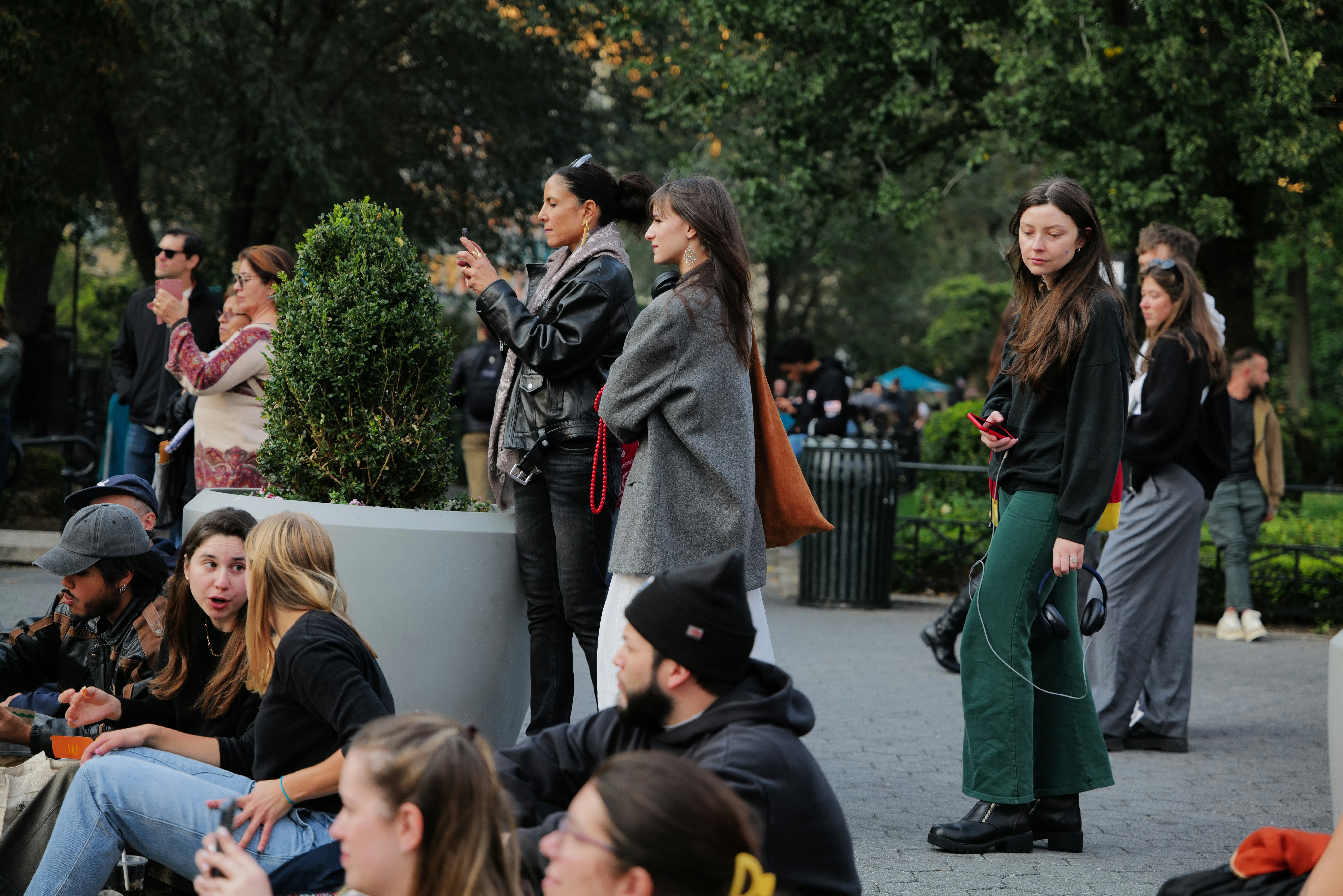 A group of people sitting and standing around each other photo – Free ...