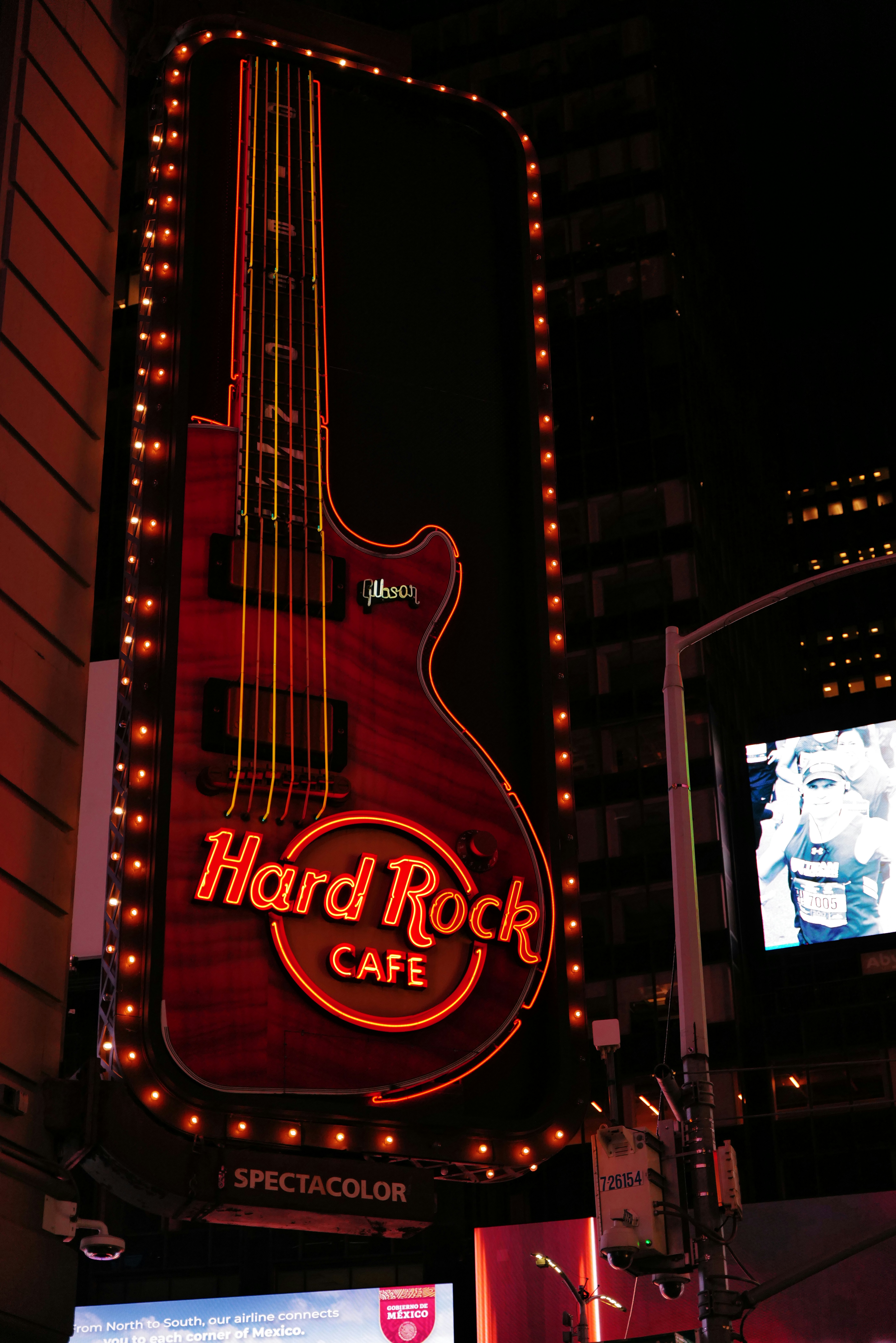 Giant Neon Guitar Billboard Illuminates the Night Street