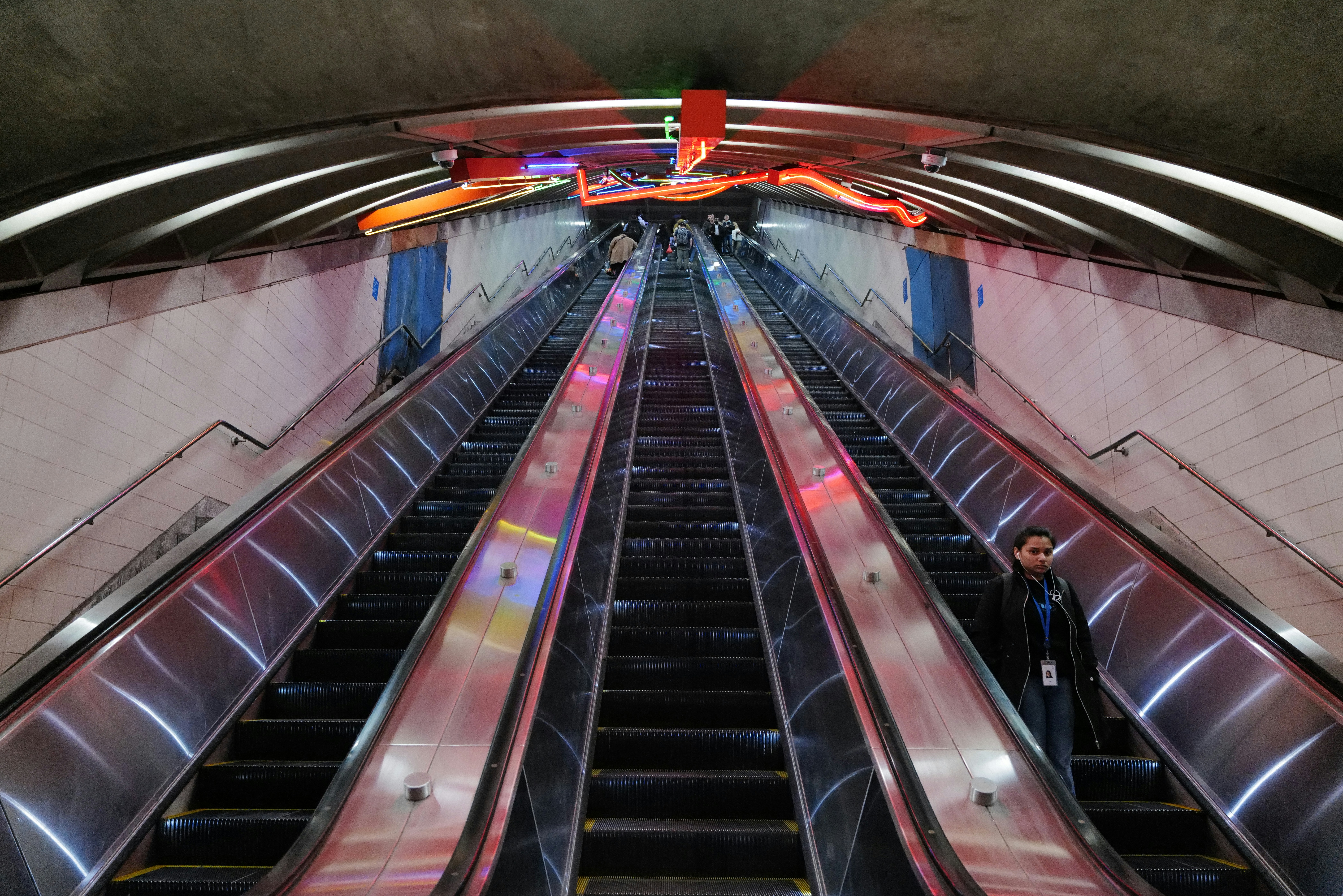 A group of people riding down an escalator photo – Free Banister Image ...