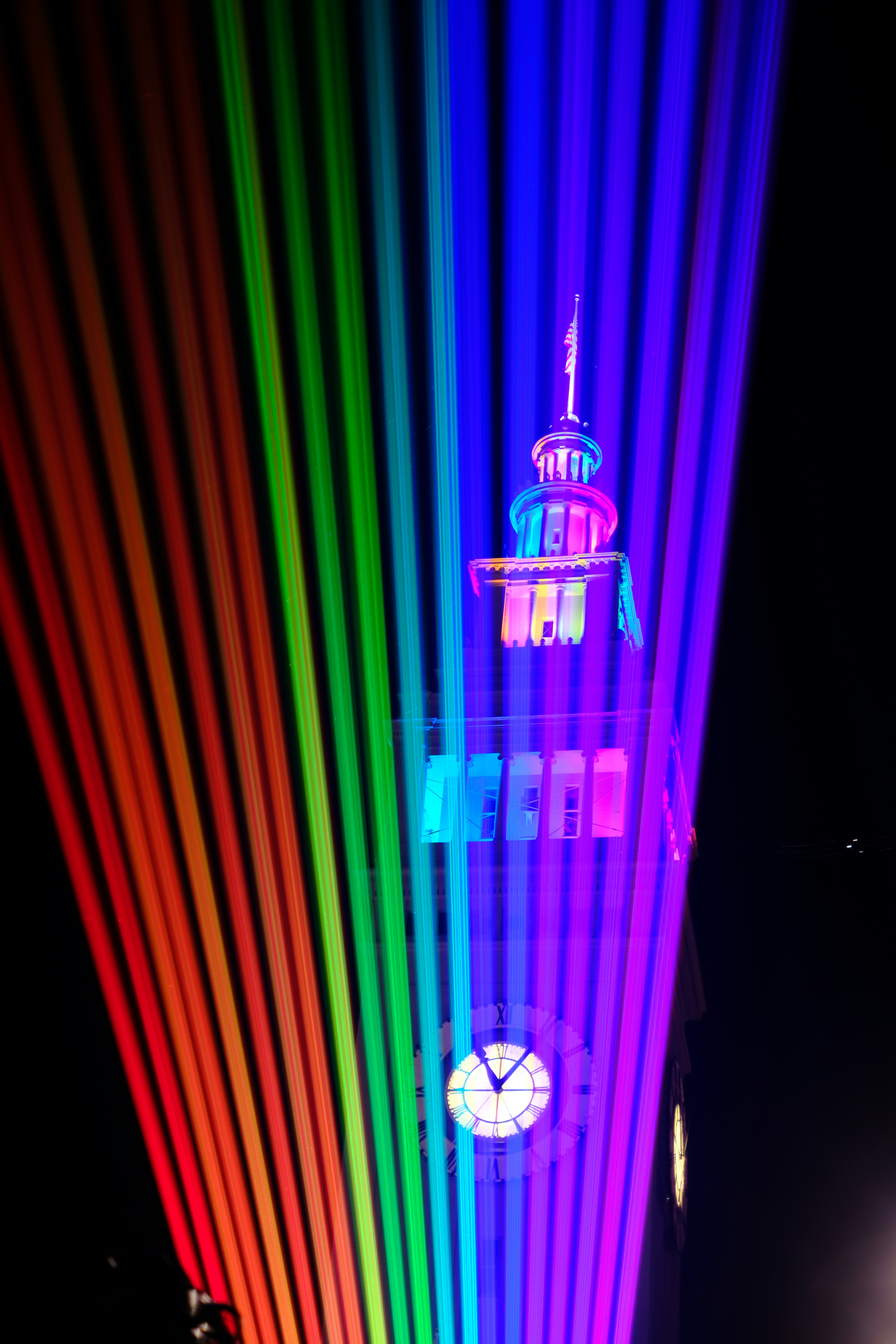 Chromatic Beams Crown a Night Clock Tower