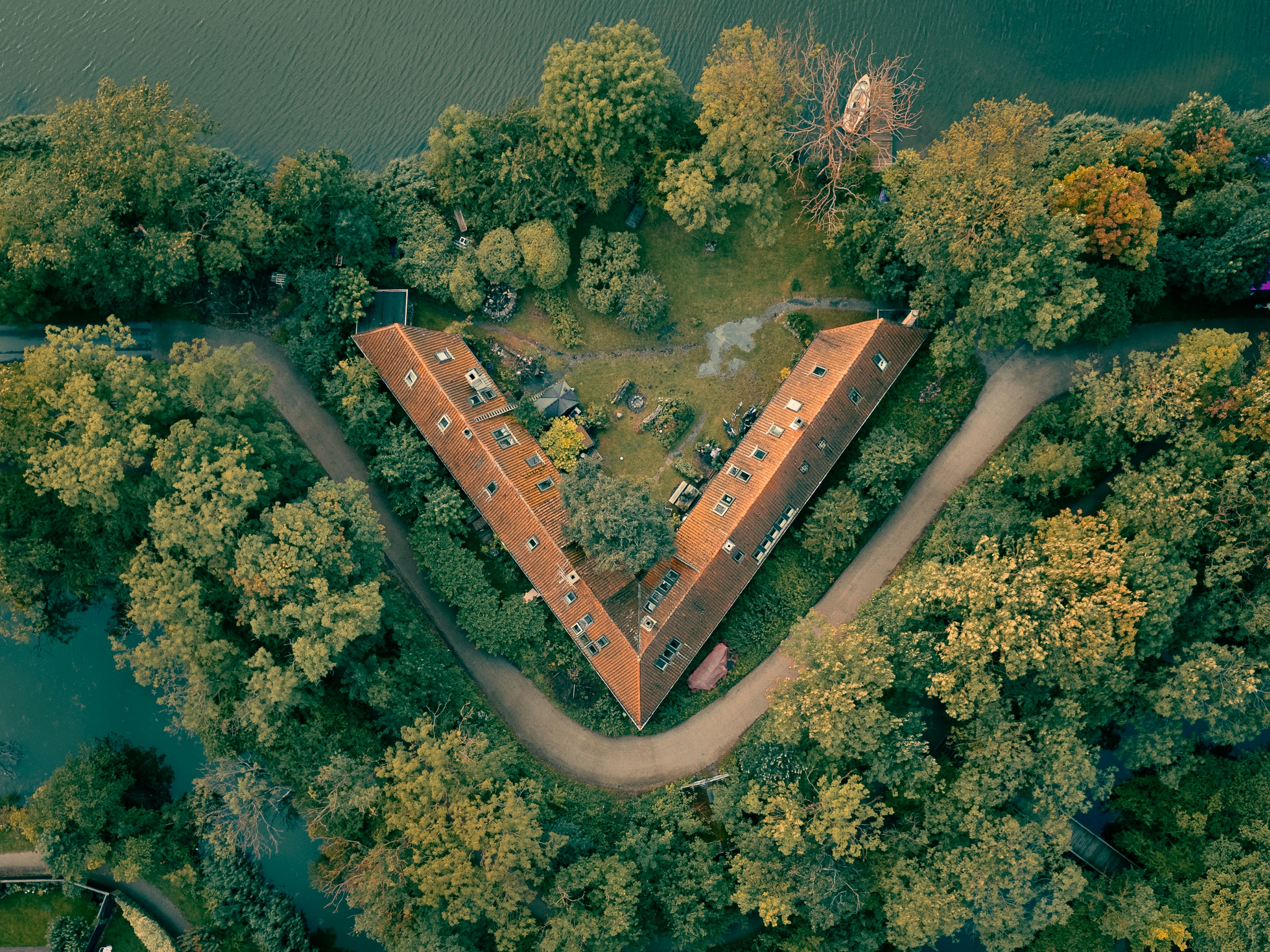 V-Formed Lodge Nestled Along a Riverside Forest Canopy