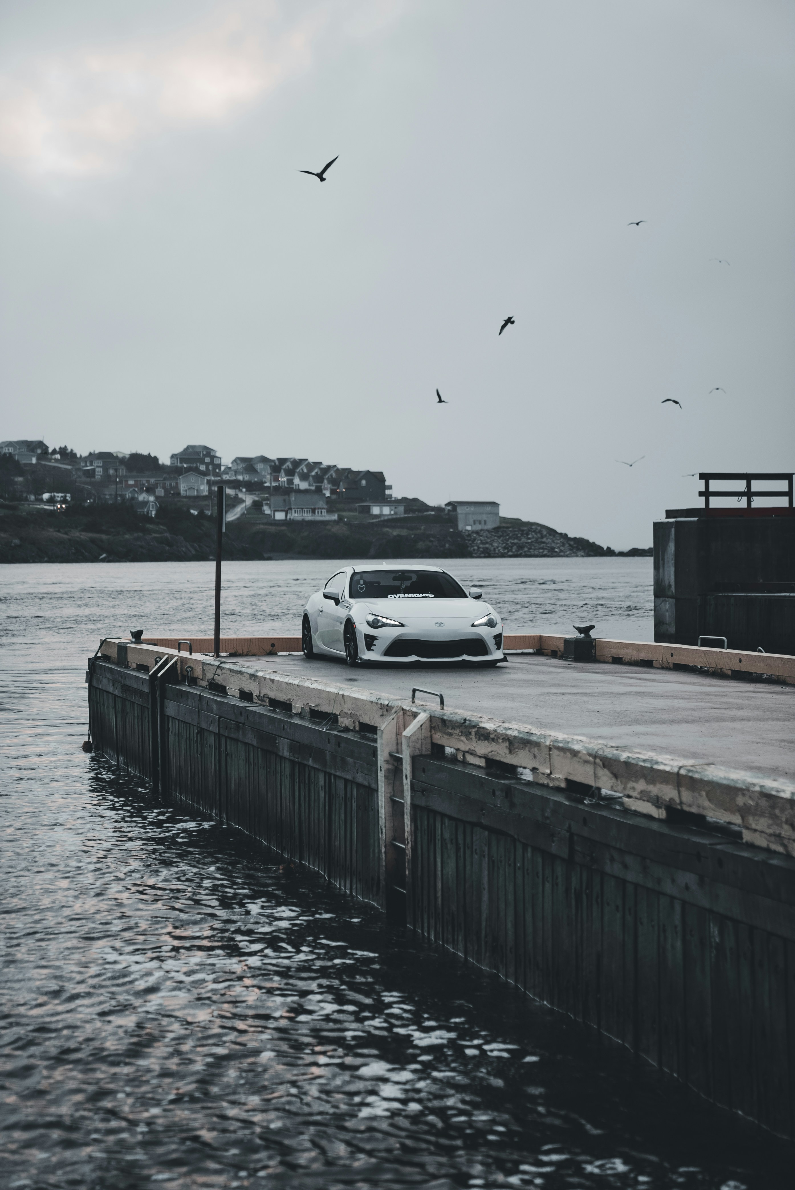 A white car is parked on a dock photo – Free Water Image on Unsplash