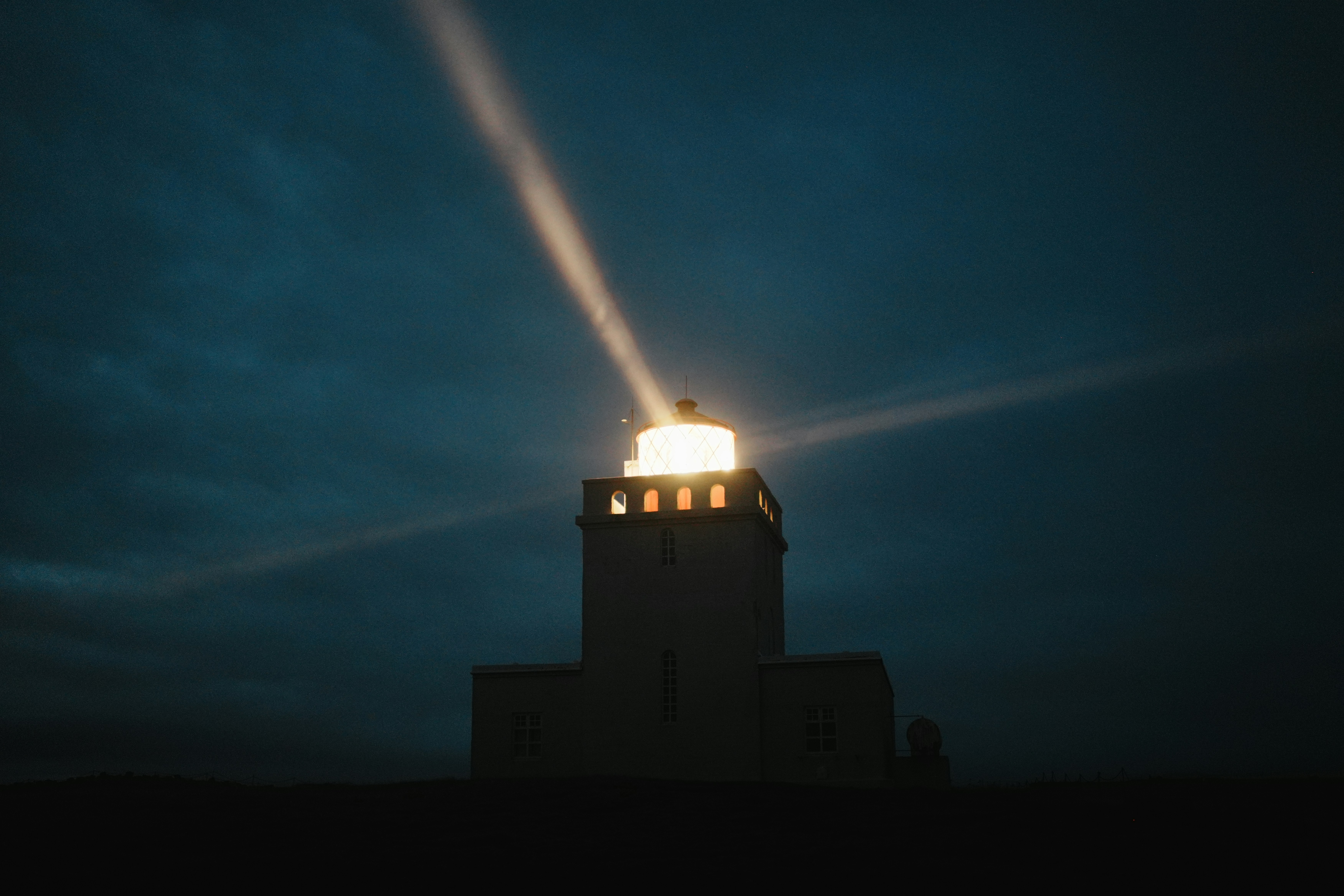 Night Beacon: A Lone Lighthouse Splits the Dark with a Diagonal Beam