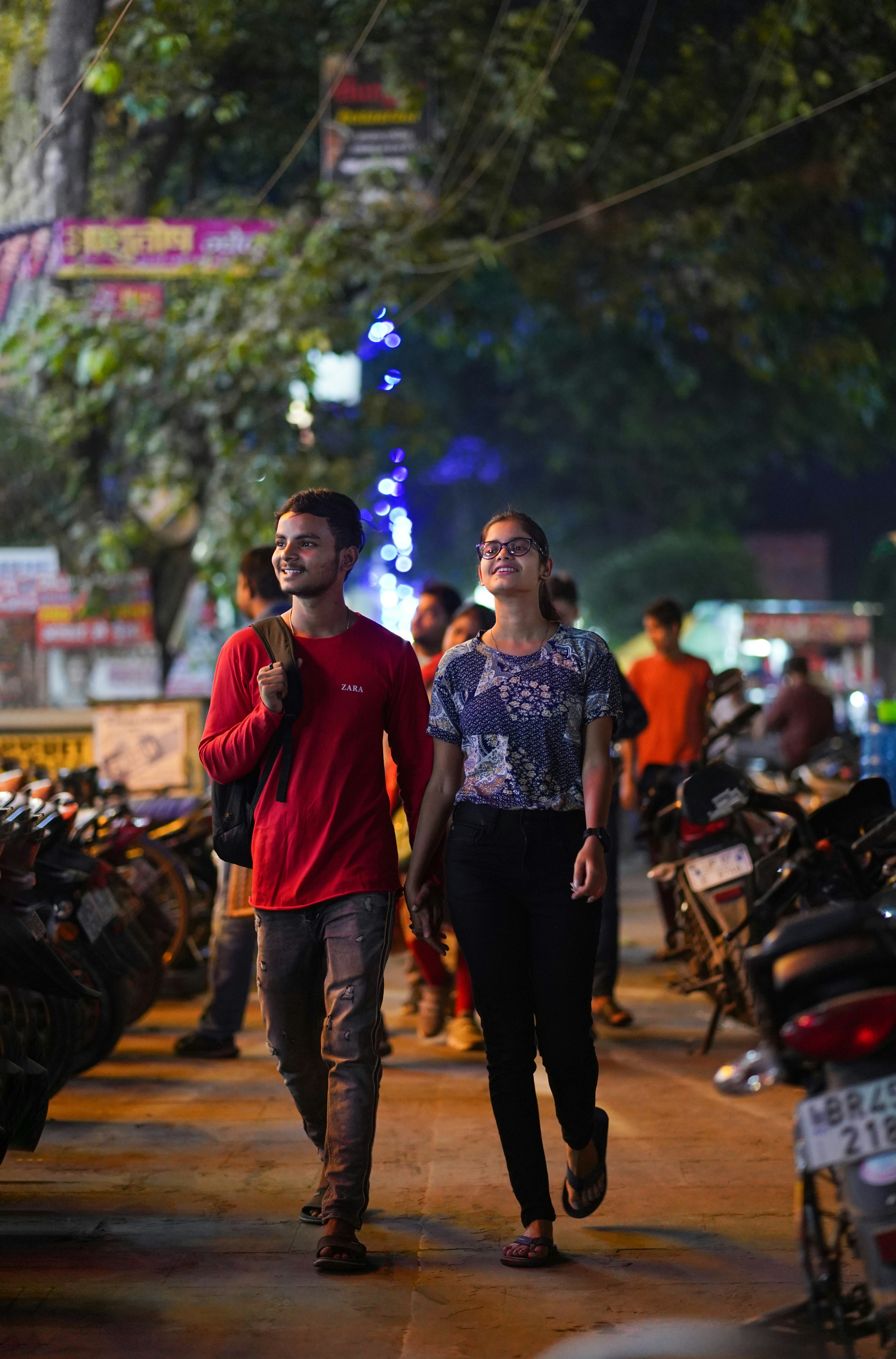 Night Market Stroll: Duo Under Neon Bokeh on a Bustling Street